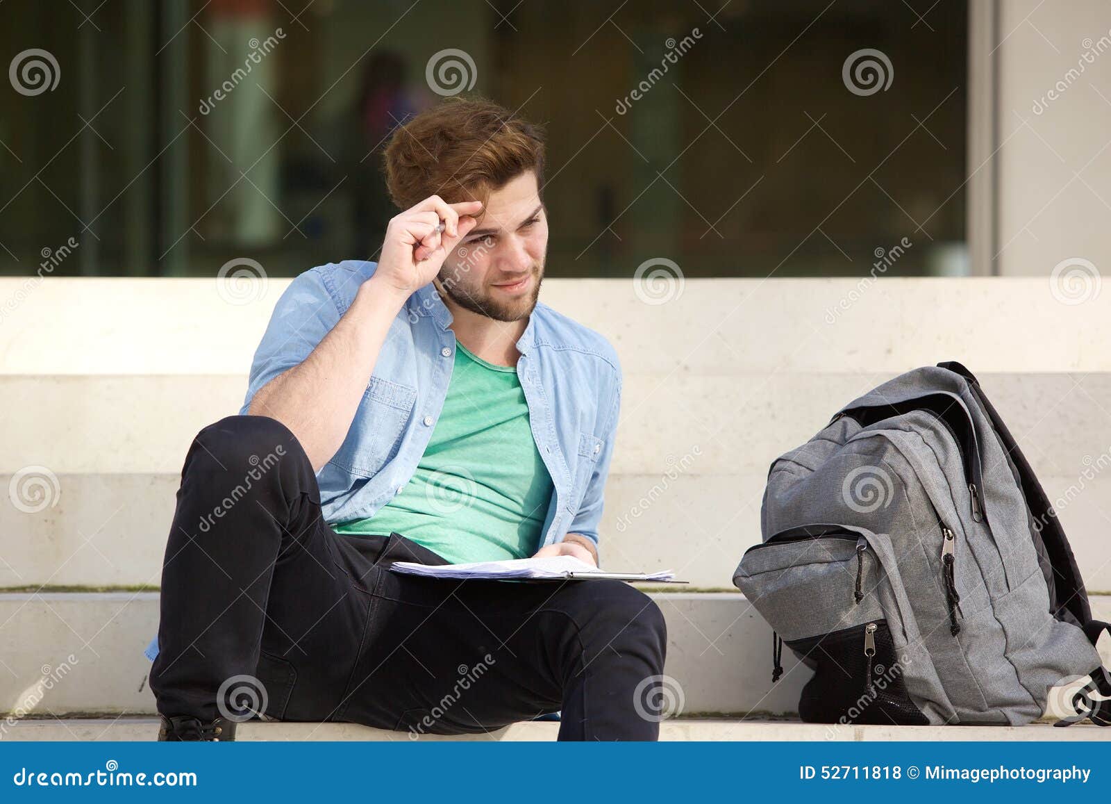 Male College Student Sitting Outside Thinking with Notepad Stock Photo ...
