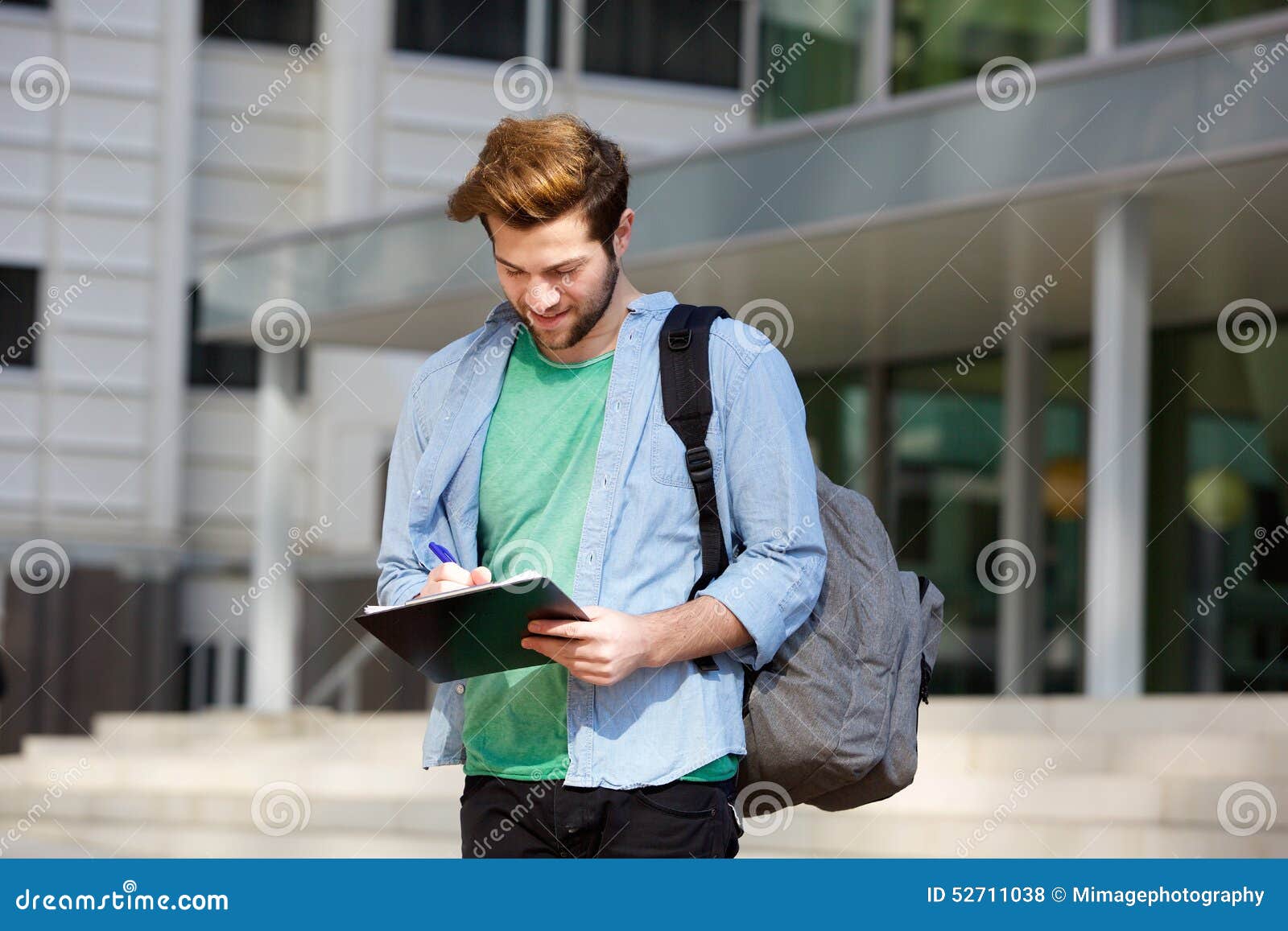 Male College Student Standing Outside with Notepad and Bag Stock Photo ...