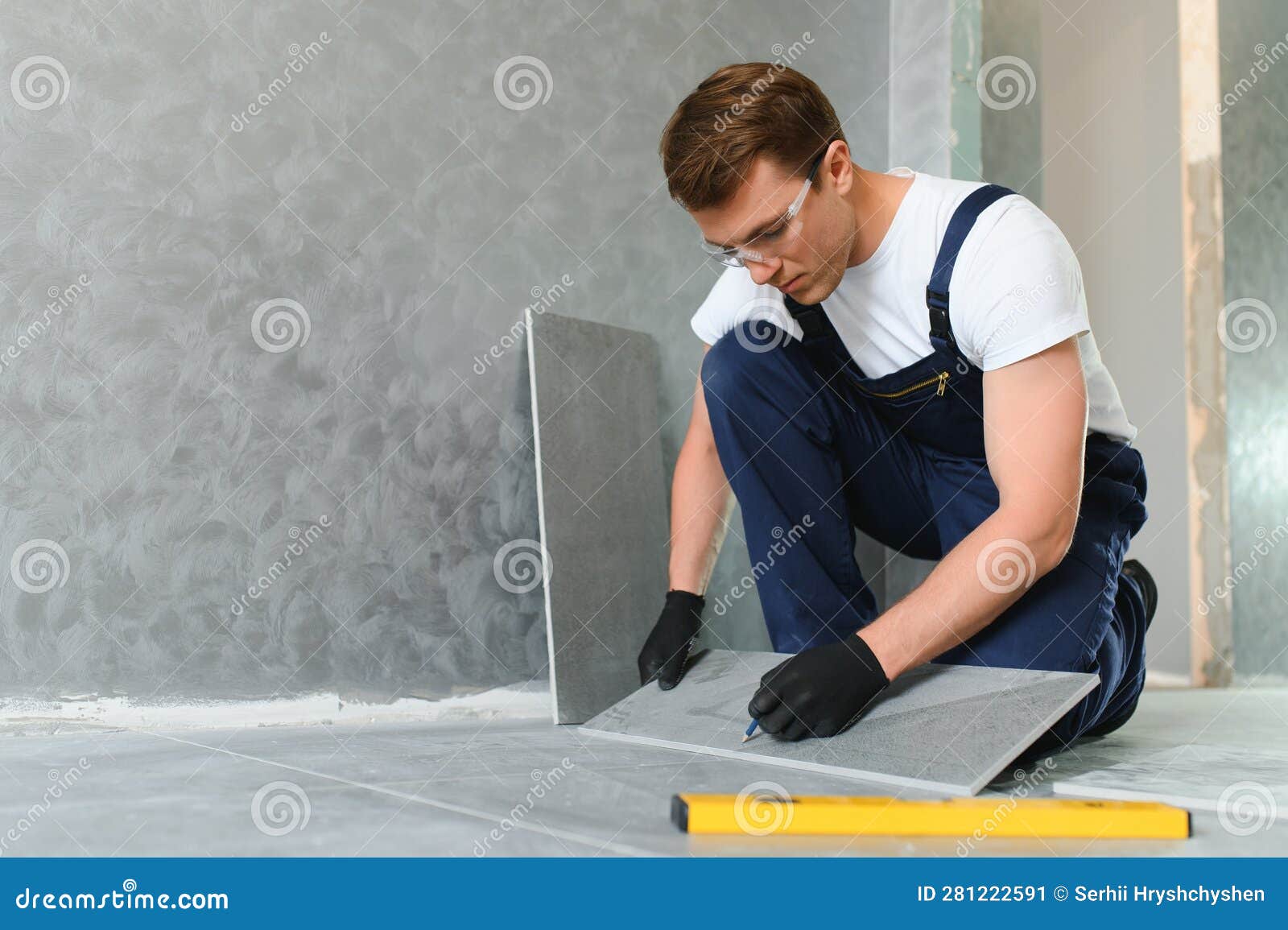 A Male Construction Worker Installs a Large Ceramic Tile Stock Image ...
