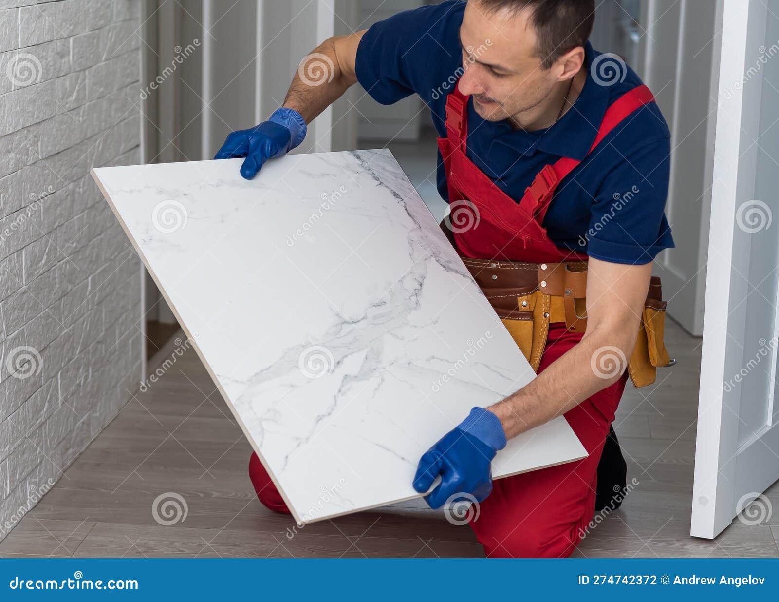A Male Construction Worker Installs a Large Ceramic Tile Stock Photo ...