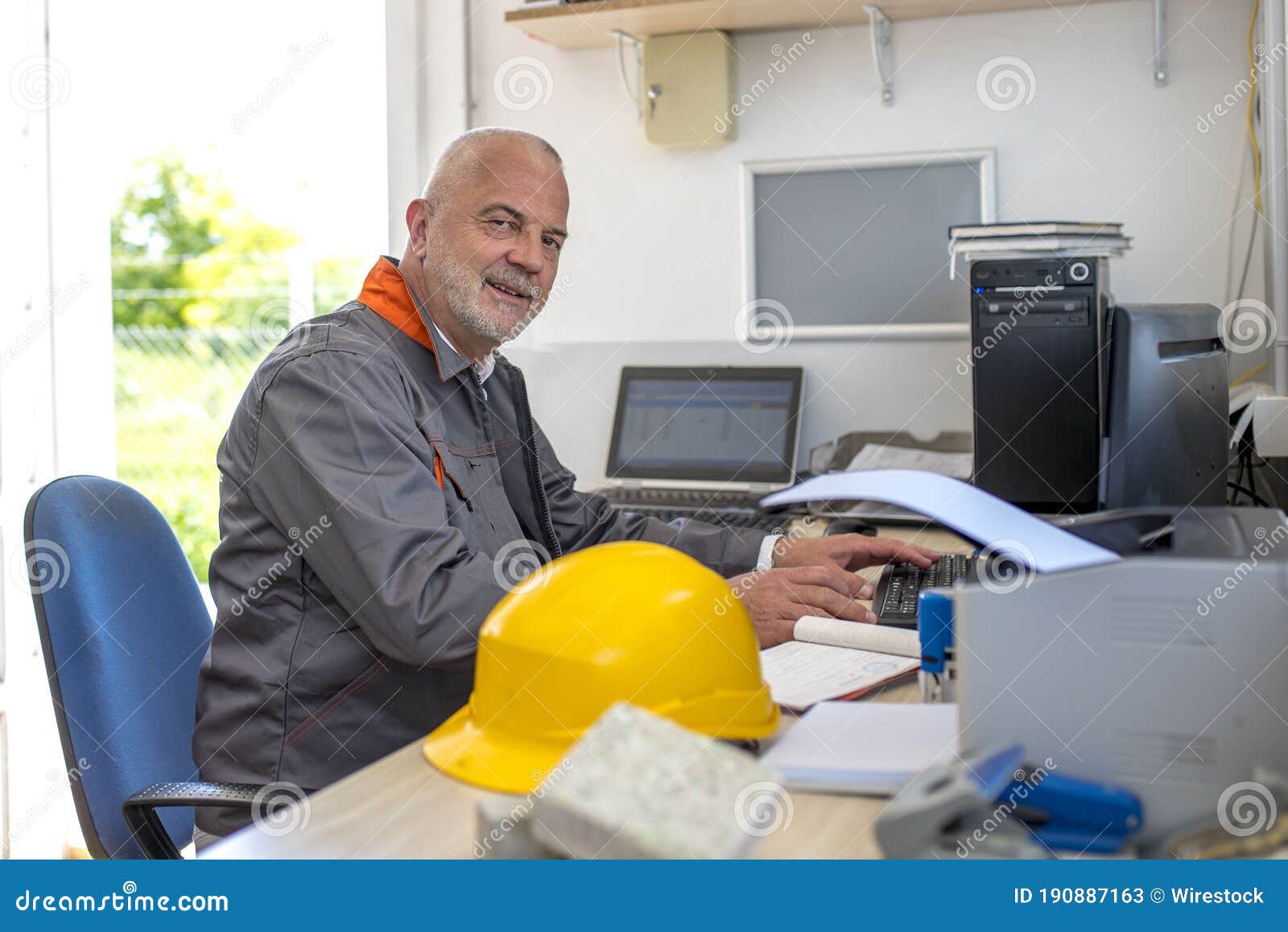 Male Construction Worker Using the Computer on the Desk Under the ...