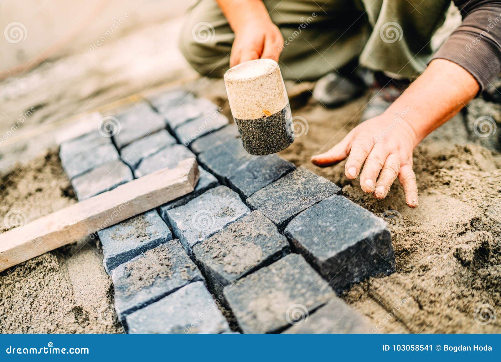 Construction Worker Using Granite Cobblestone Blocks To Create Path or ...