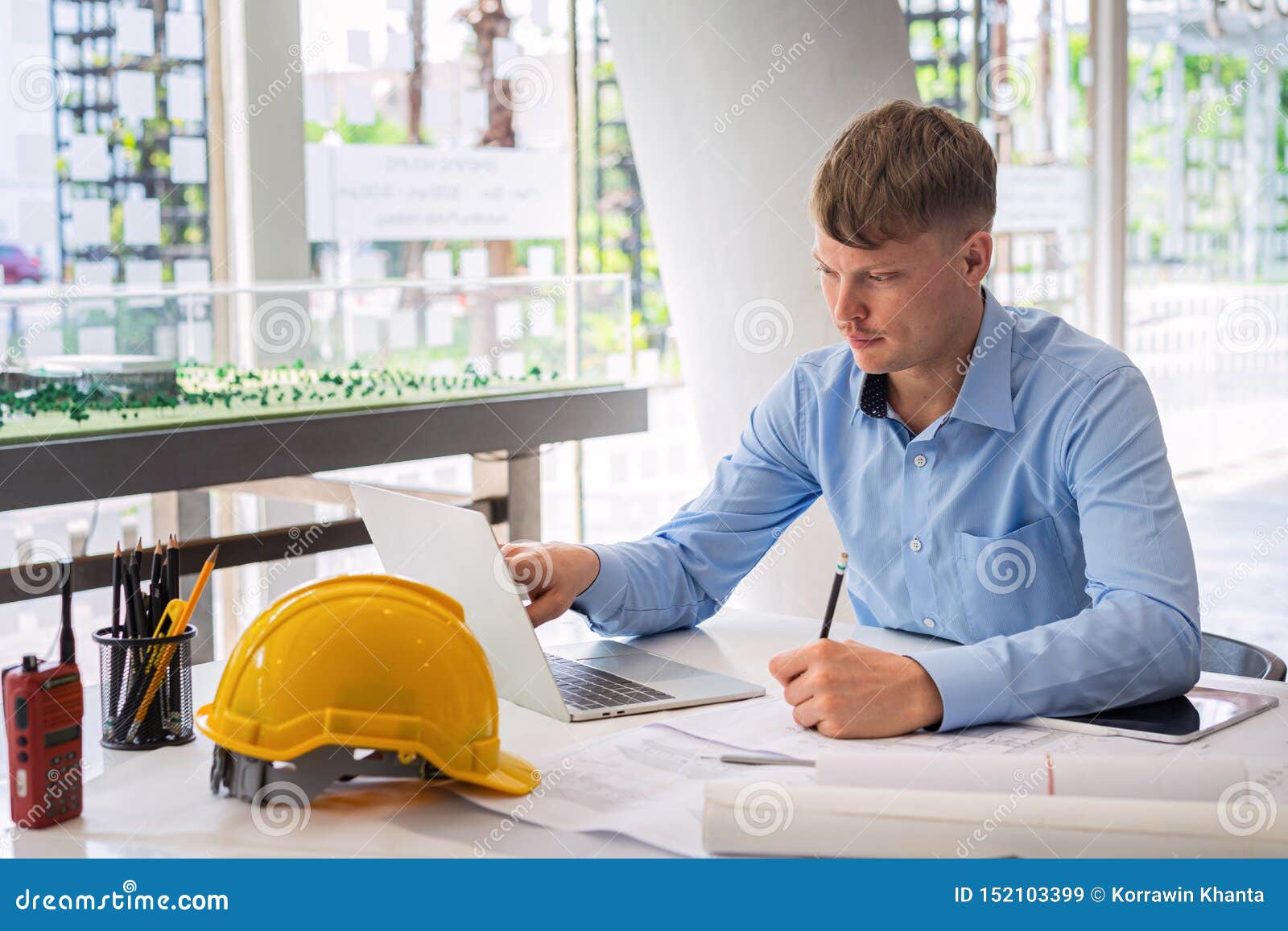 Male Construction Worker Working with Laptop and Blueprints at ...