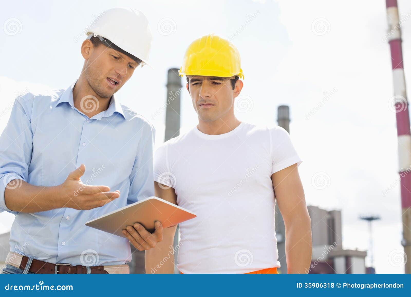 Male Construction Workers Discussing Over Digital Tablet at Industry ...