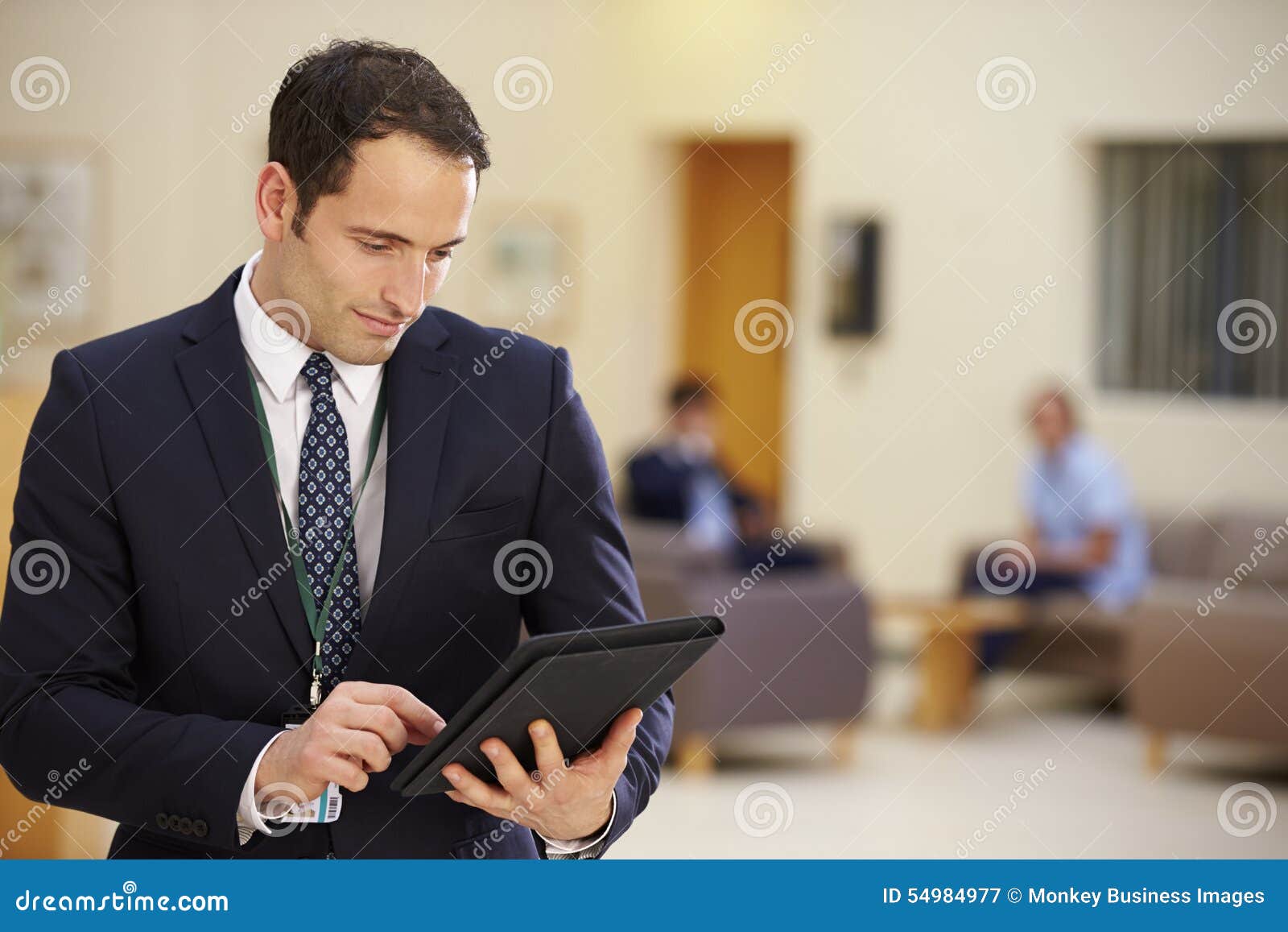 Male Consultant Using Digital Tablet in Hospital Reception Stock Image ...