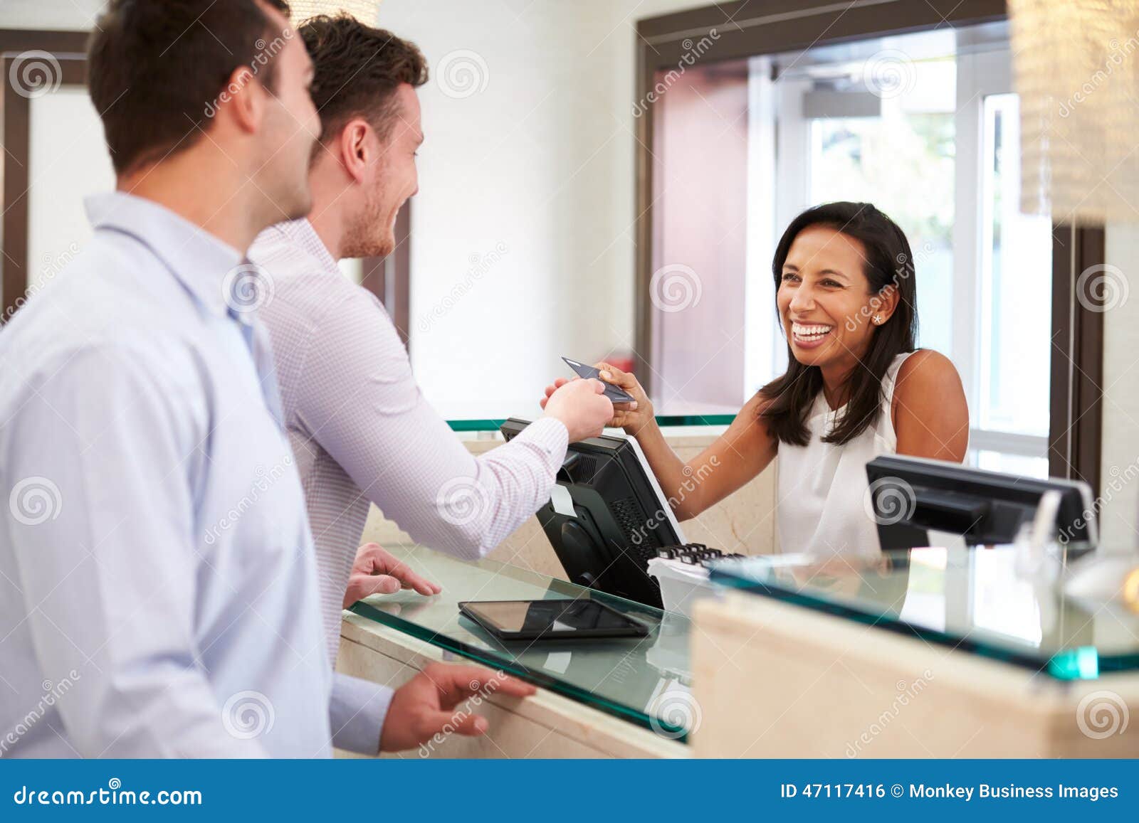 Male Couple Checking in at Hotel Reception Stock Photo - Image of ...