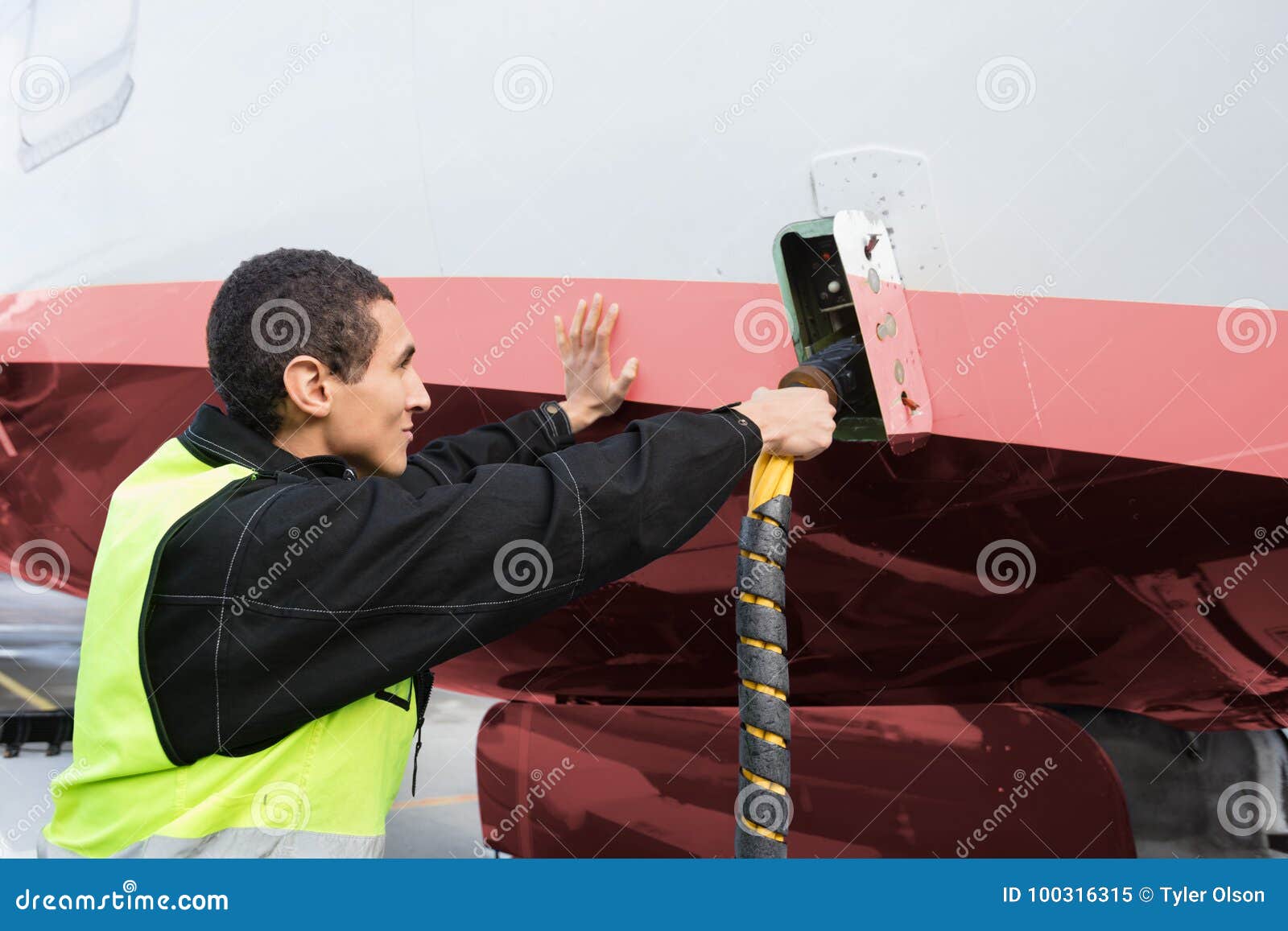 Male Crew Member Charging Airplane on Runway Stock Image - Image of ...