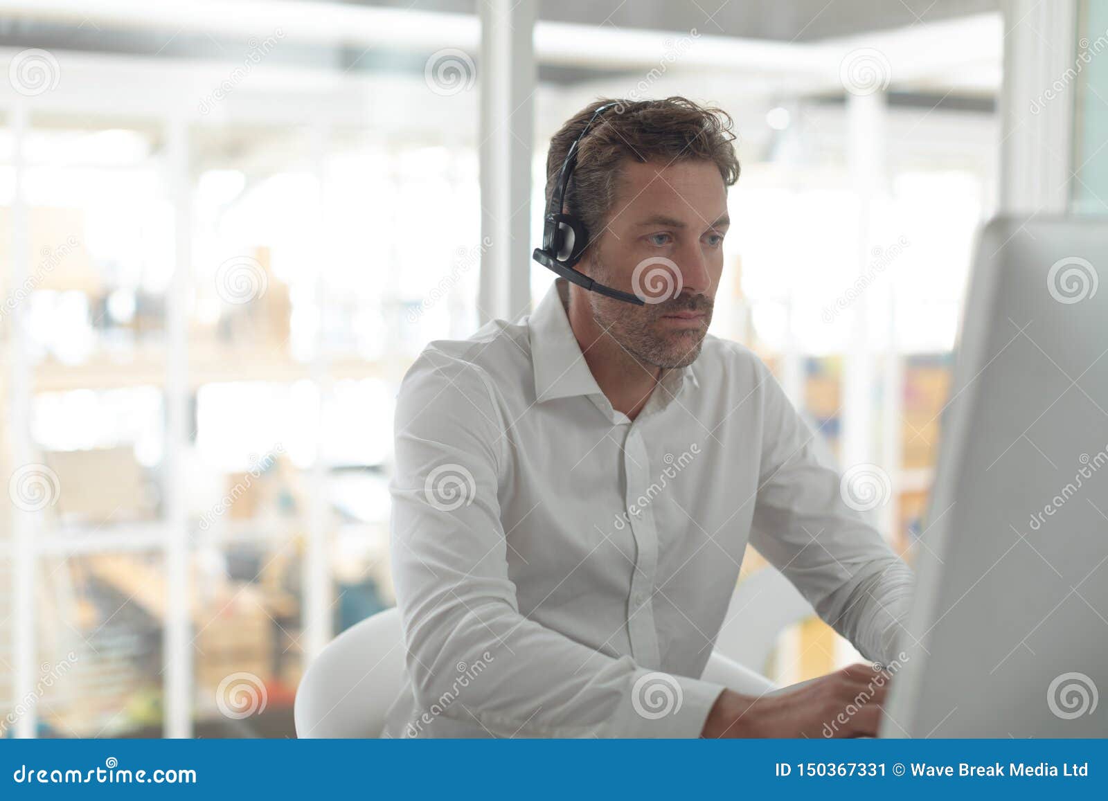 Male Customer Service Executive Working at Desk in a Modern Office ...