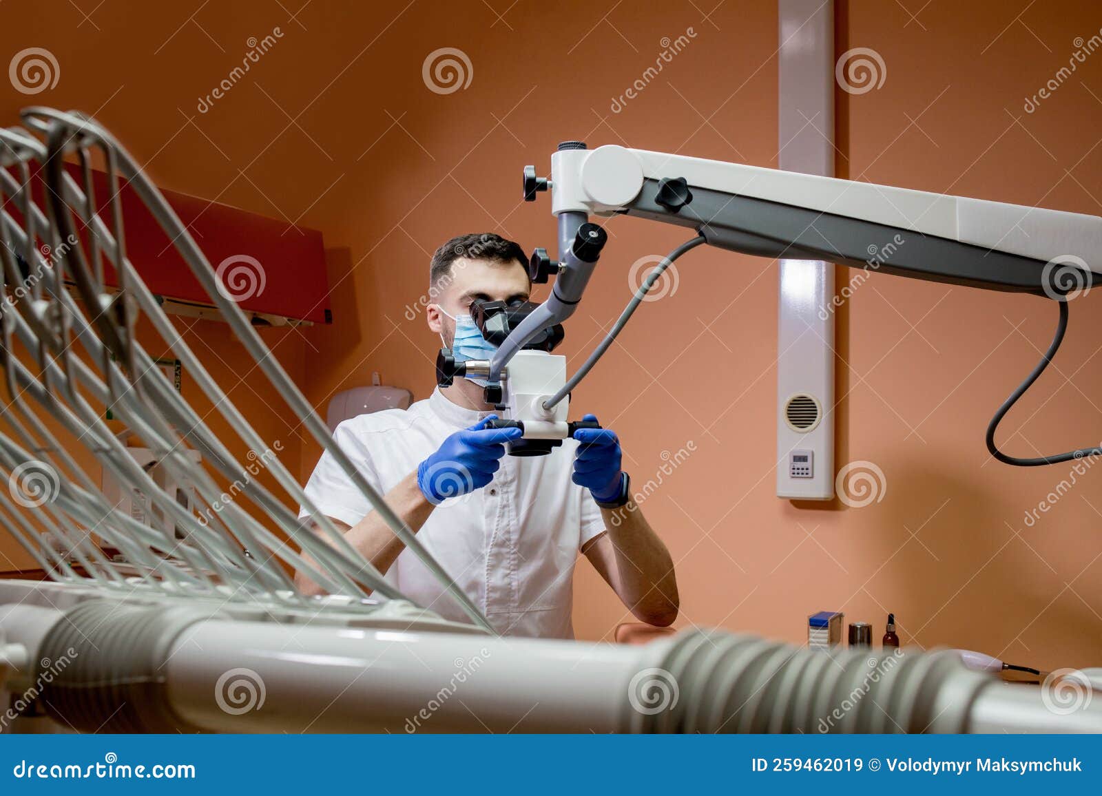 A Male Dentist Looks into a Microscope. Modern Dentistry Using New ...