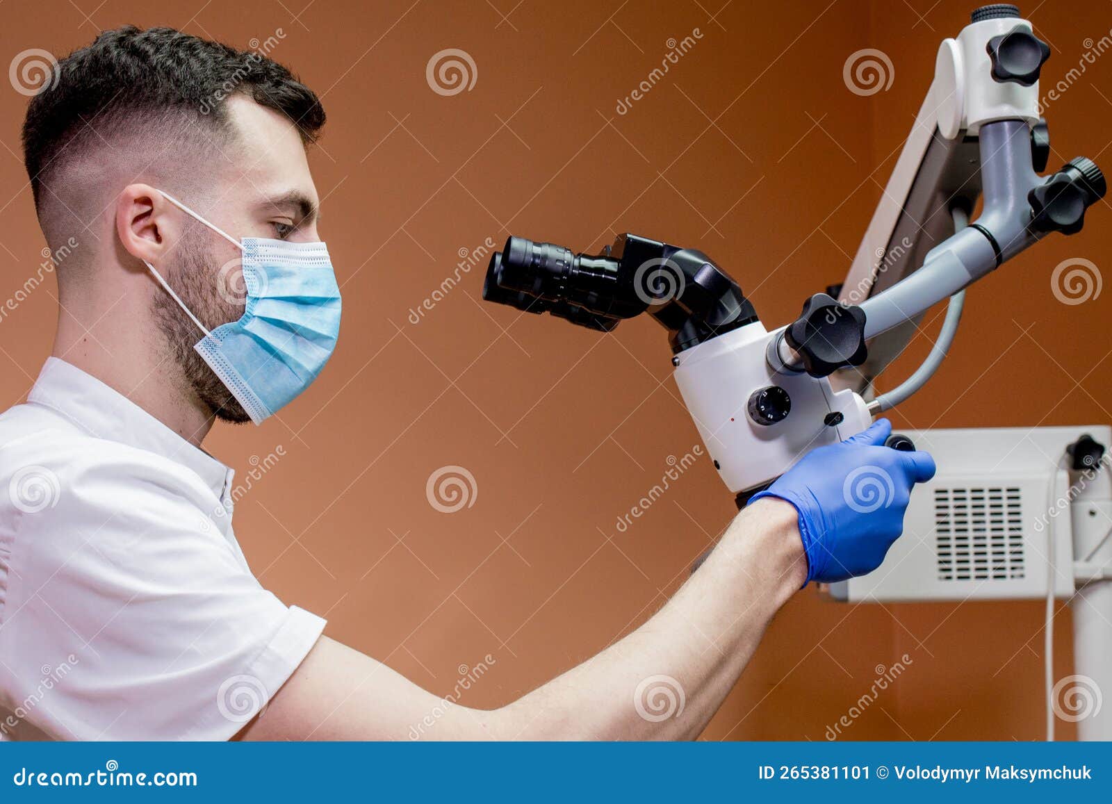 A Male Dentist Looks into a Microscope. Modern Dentistry Using New ...