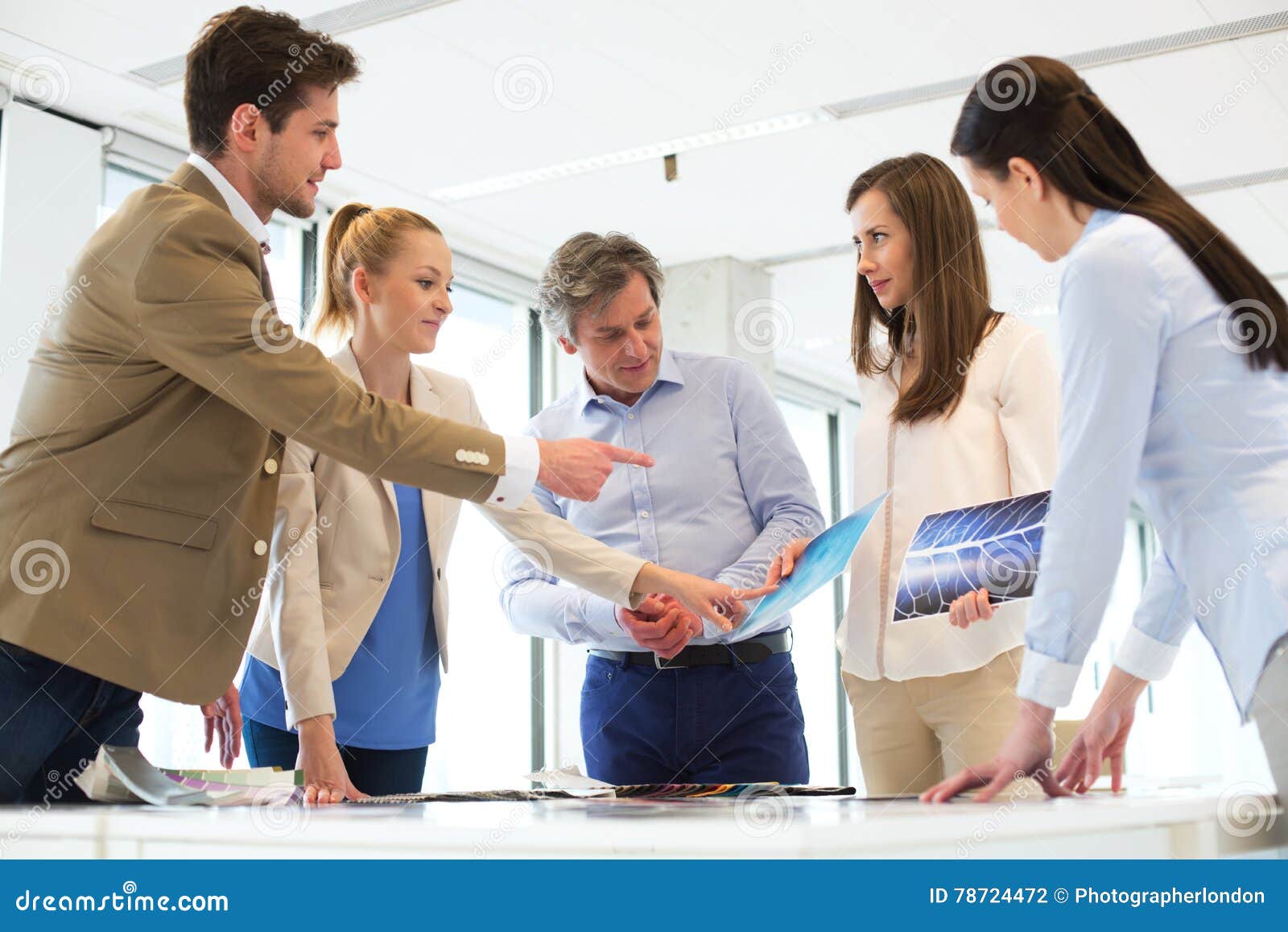 Male Design Professional with Team Discussing at Table in New Office ...