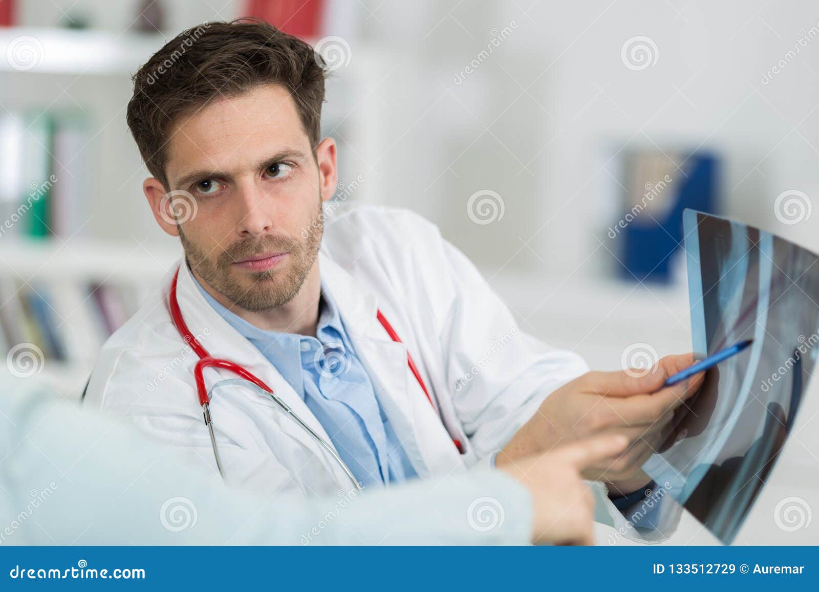 Male Doctor with Patient Looking at X-ray at Office Stock Image - Image ...