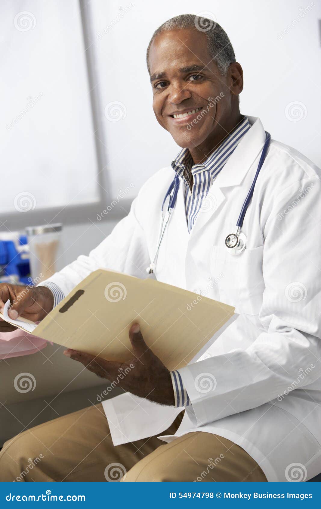 Male Doctor in Surgery Reading Patient Notes Stock Photo - Image of ...