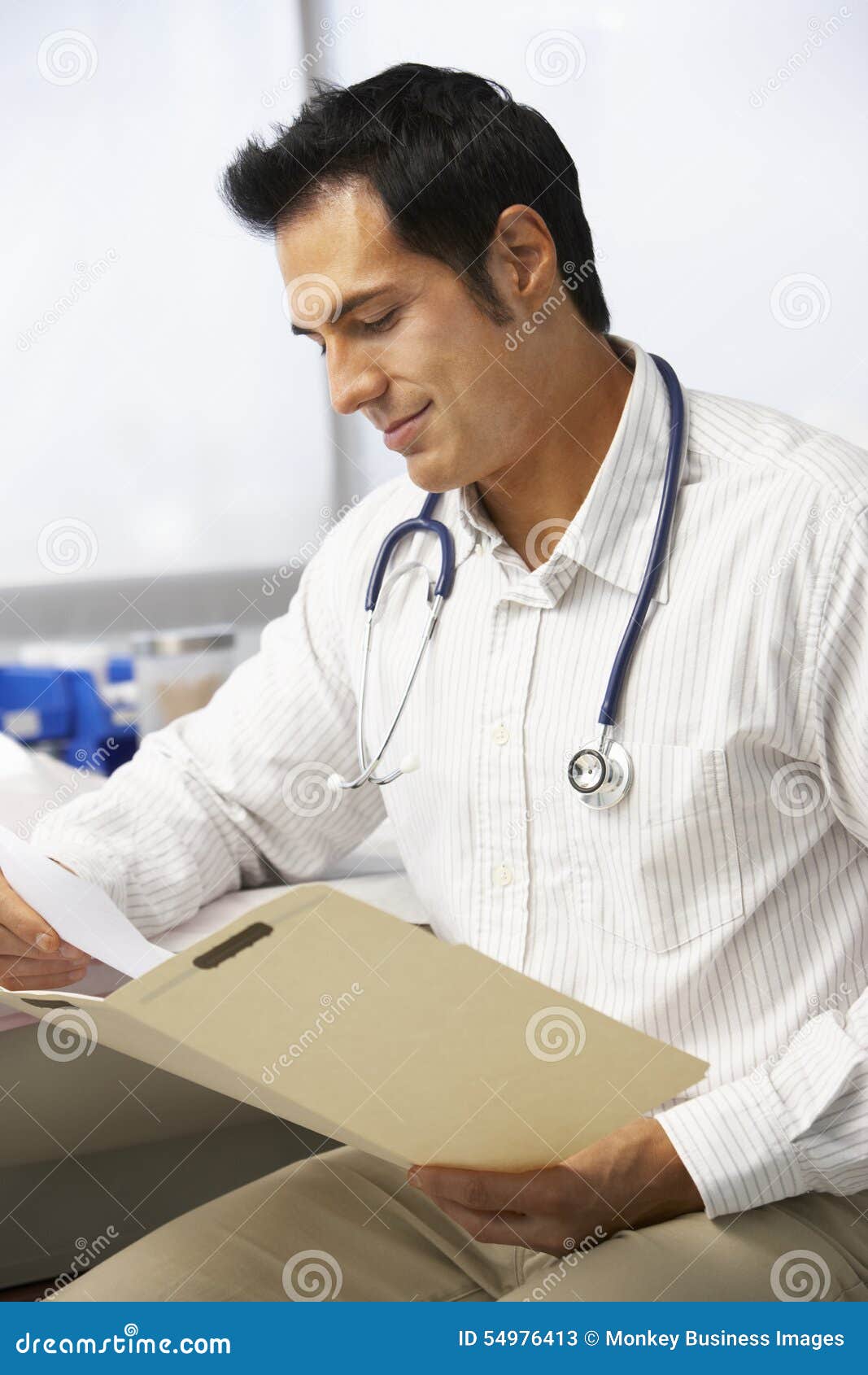 Male Doctor in Surgery Reading Patient Notes Stock Image - Image of ...