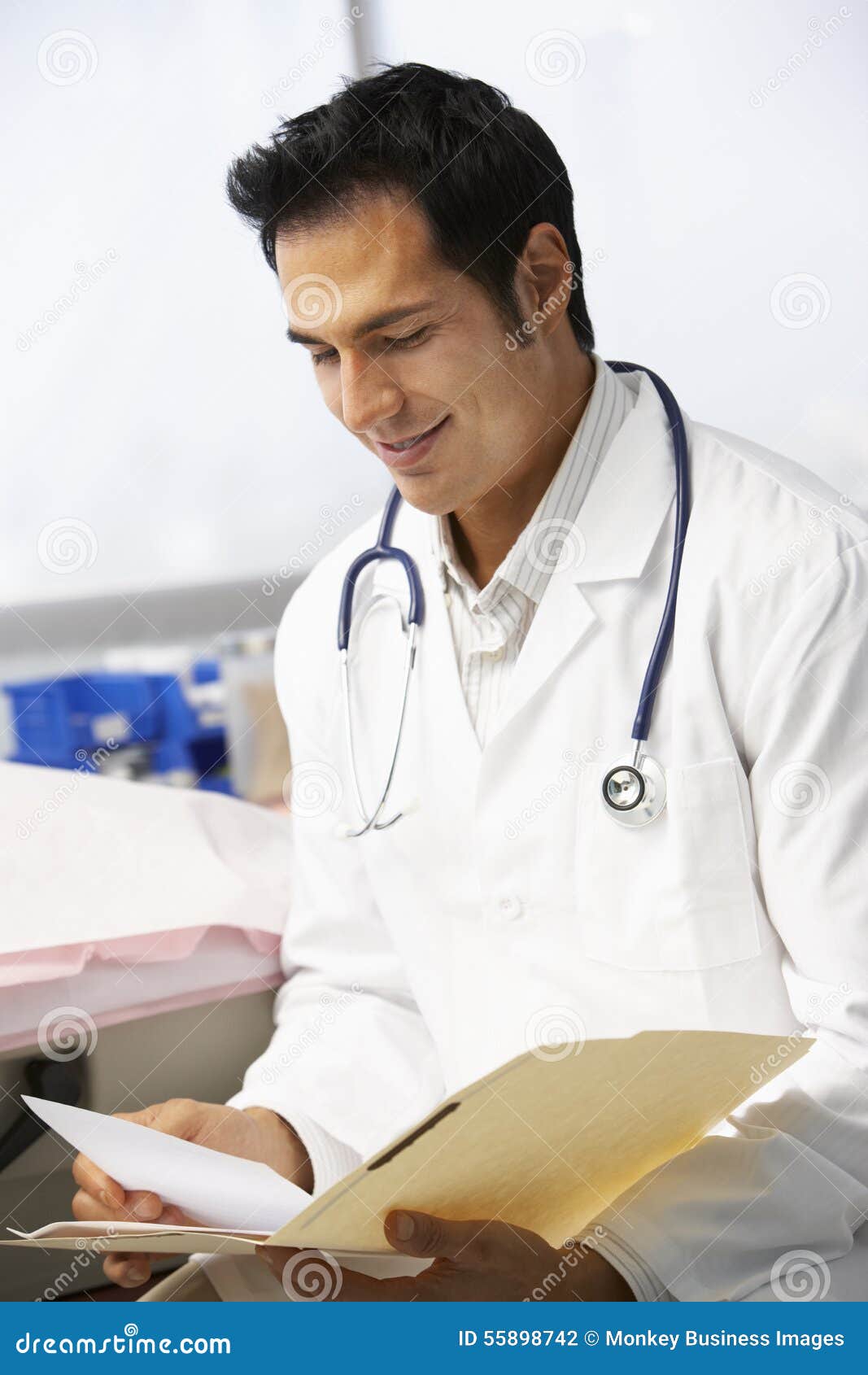Male Doctor in Surgery Reading Patient Notes Stock Photo - Image of ...