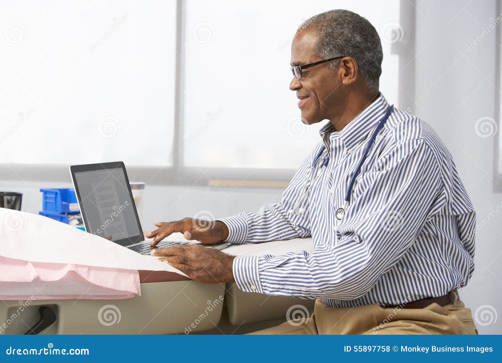 Male Doctor in Surgery Using Laptop Stock Photo - Image of copy ...