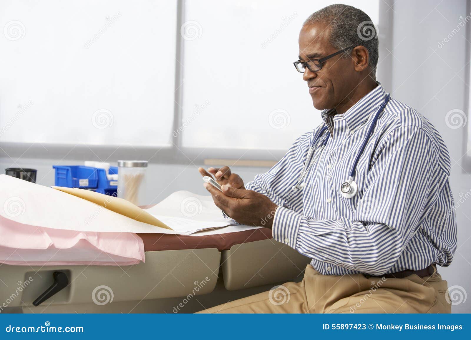 Male Doctor in Surgery Using Mobile Phone Stock Image - Image of mobile ...