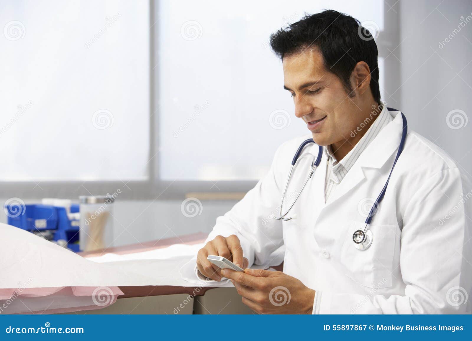 Male Doctor in Surgery Using Mobile Phone Stock Image - Image of ...
