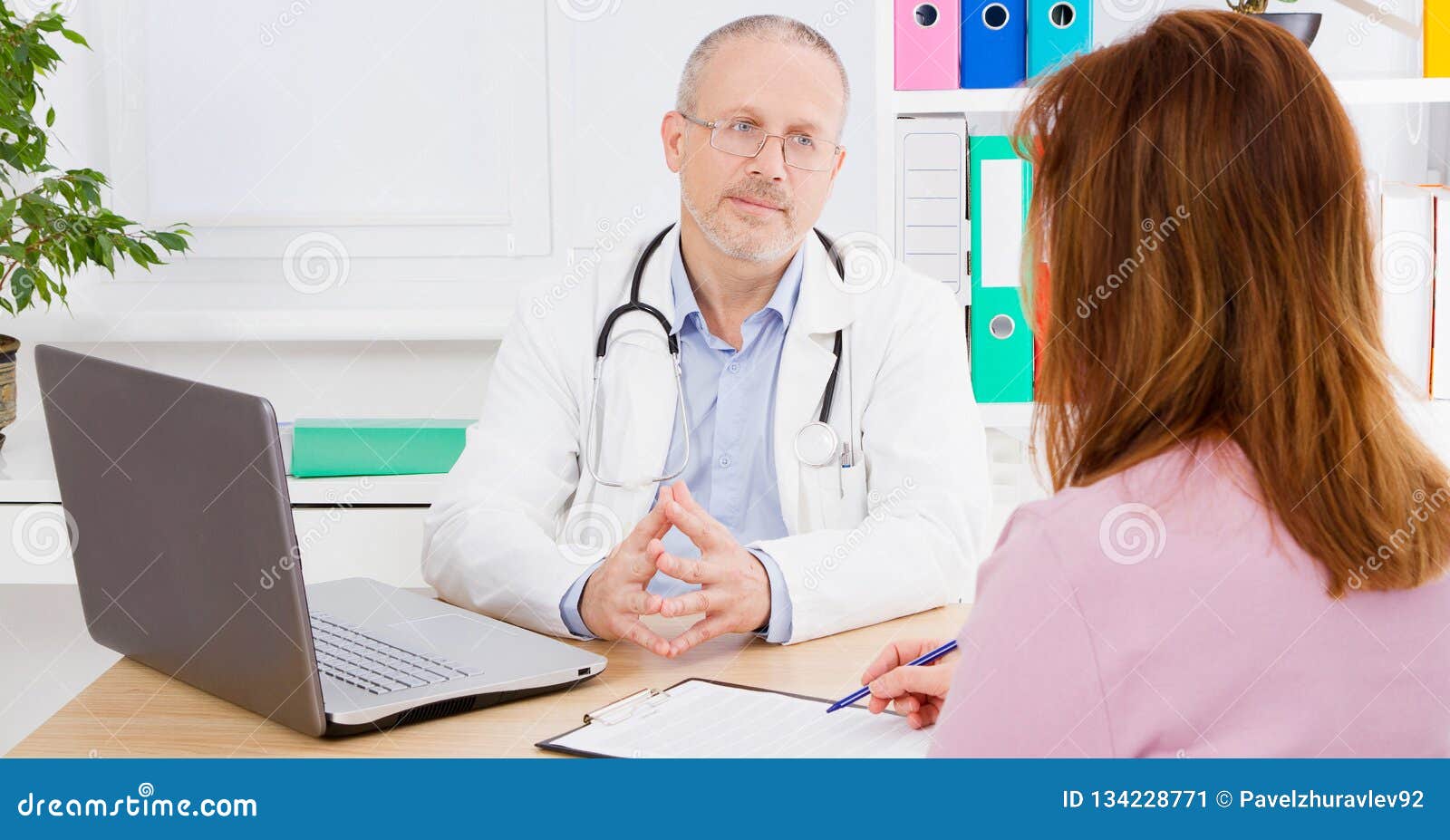 Male Doctor at the Table Communicates with the Patient Stock Image ...