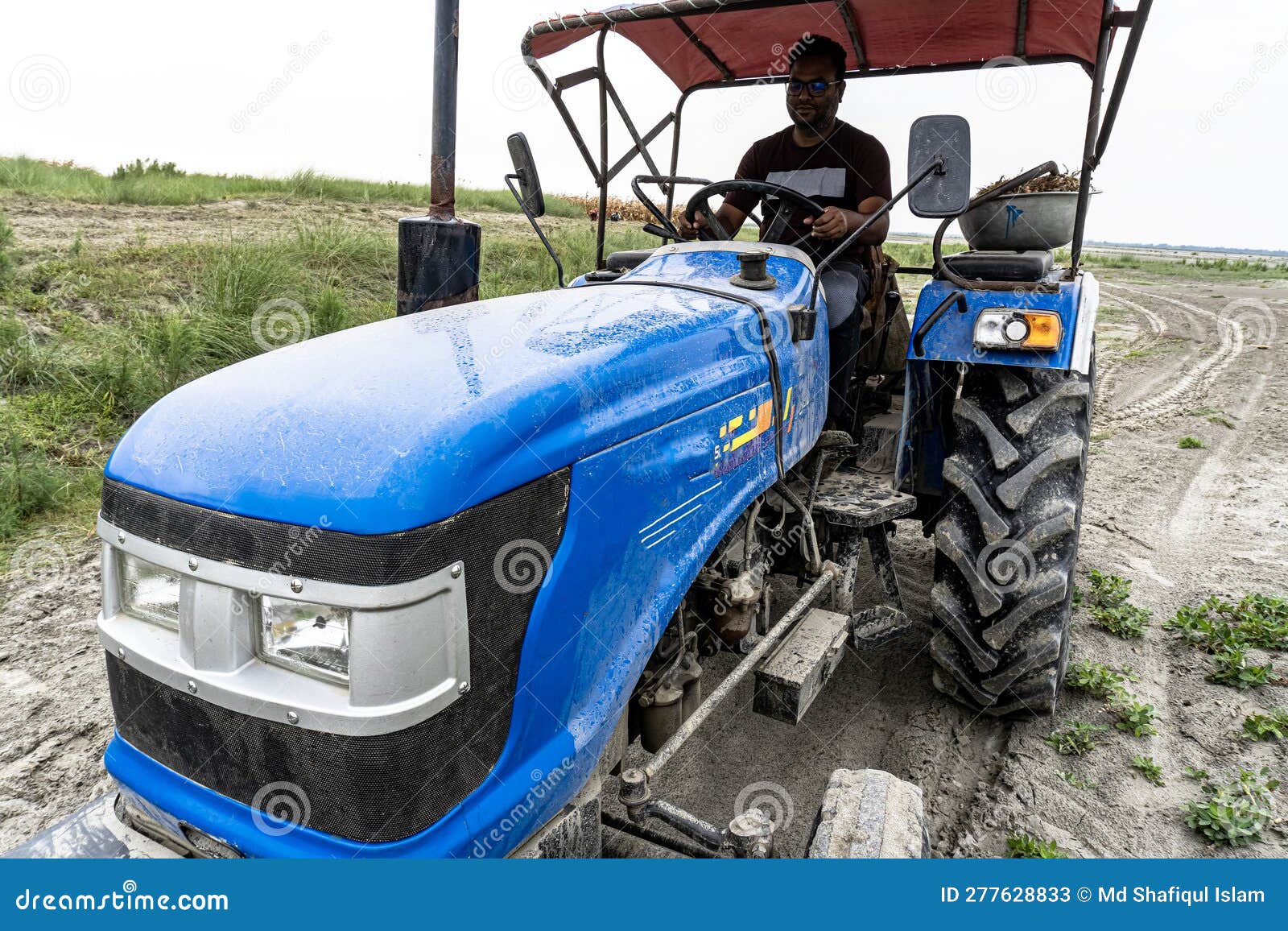Male Driver Operating Tractor. a Young Man Driving on a Tractor in the ...