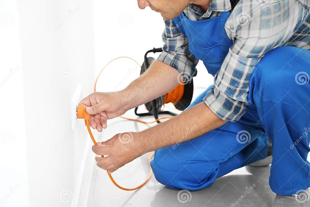 Male Electrician Inserting Plug into Socket in Order To Check Its ...