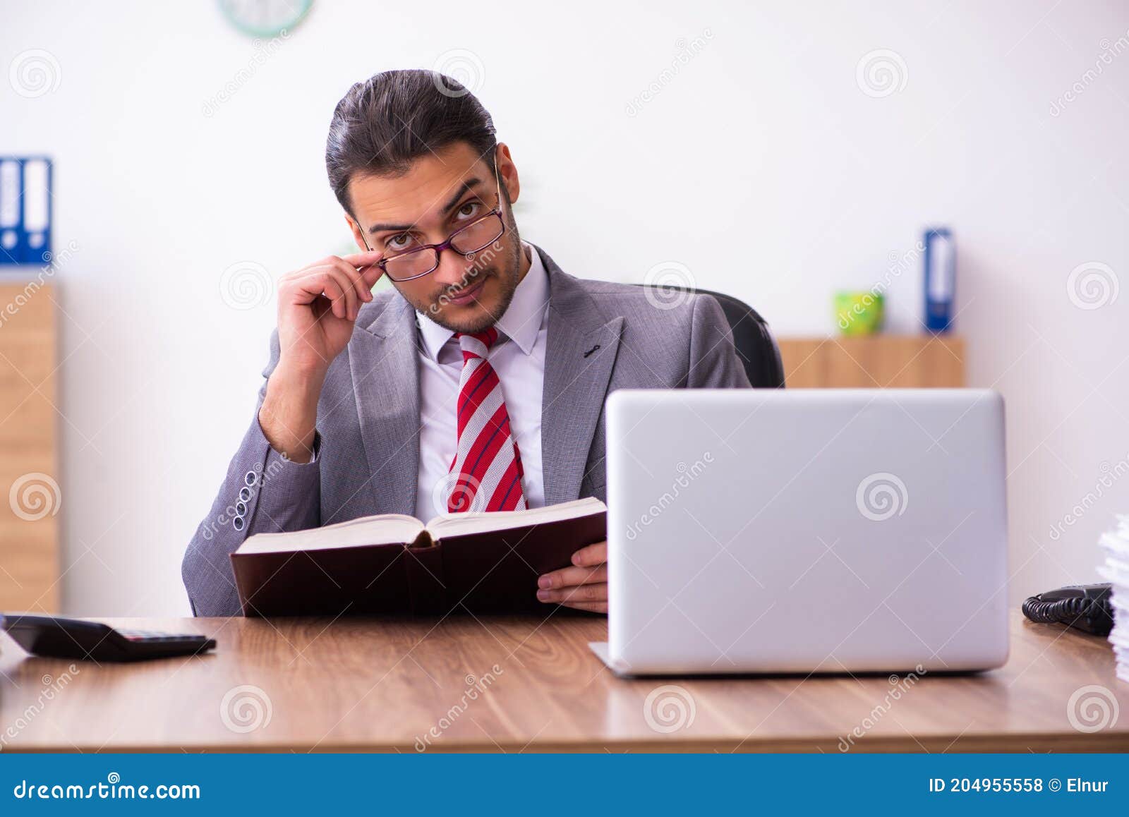 Young Male Employee Reading Book in the Office Stock Photo - Image of ...