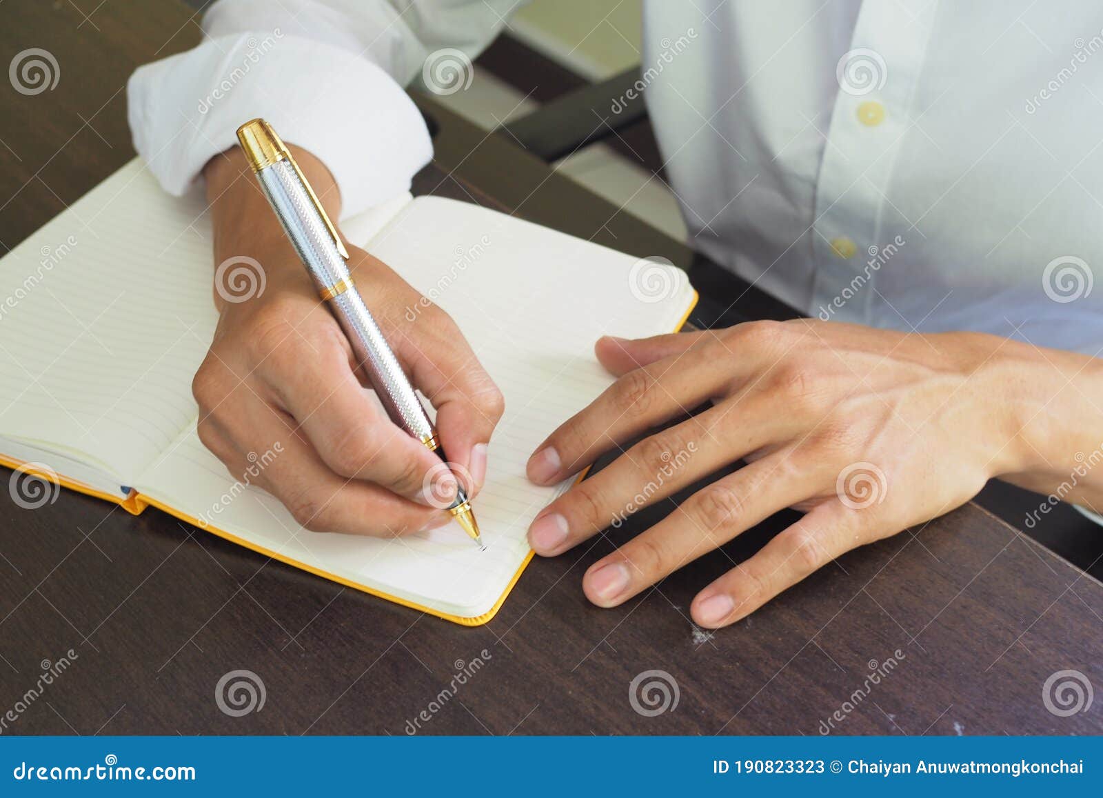 A Male Employee is Taking Notes of His Work into the Book. Writing ...