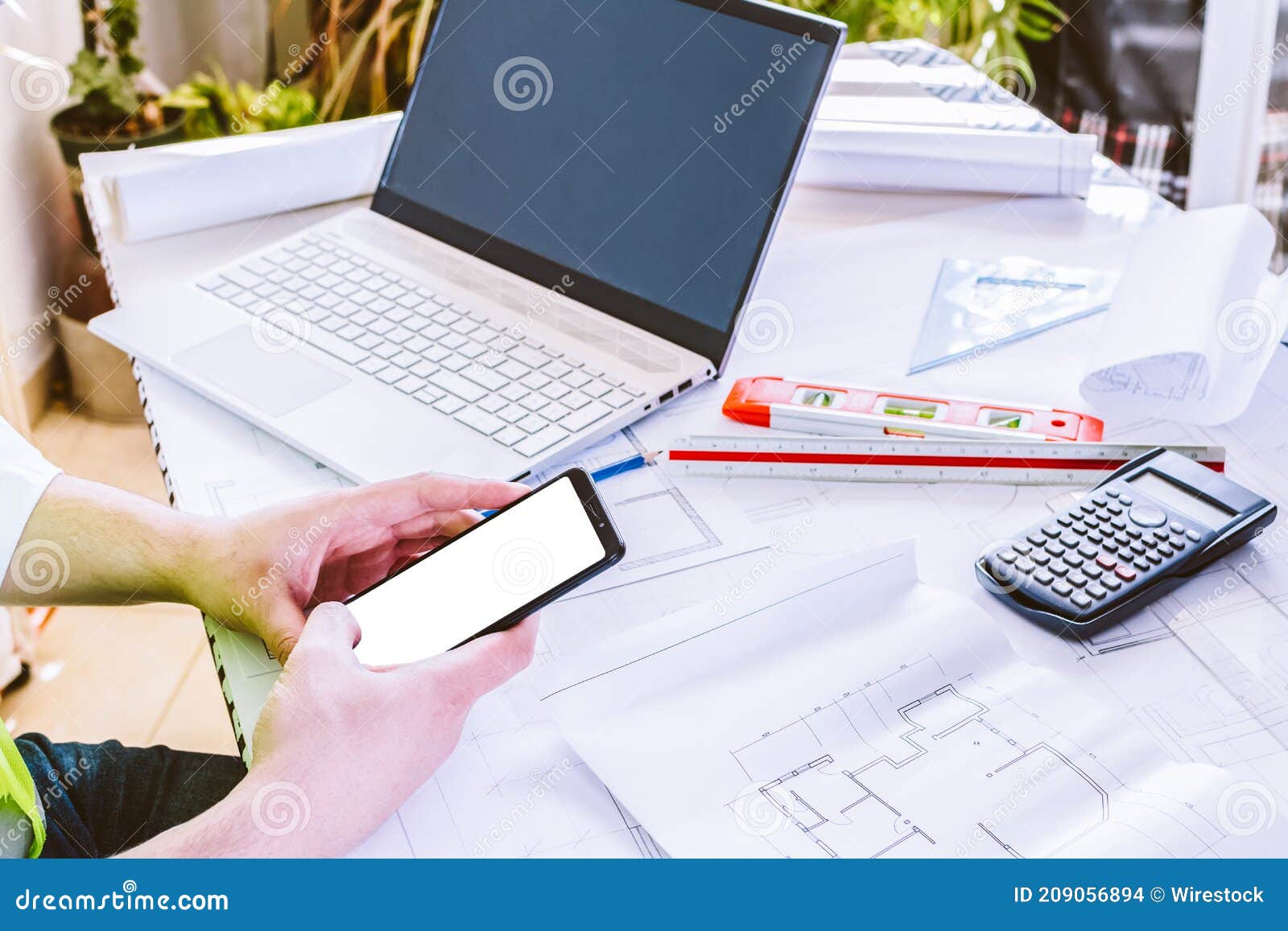 Male Engineer Hands Using a Mobile Phone while Working on Blueprints at ...