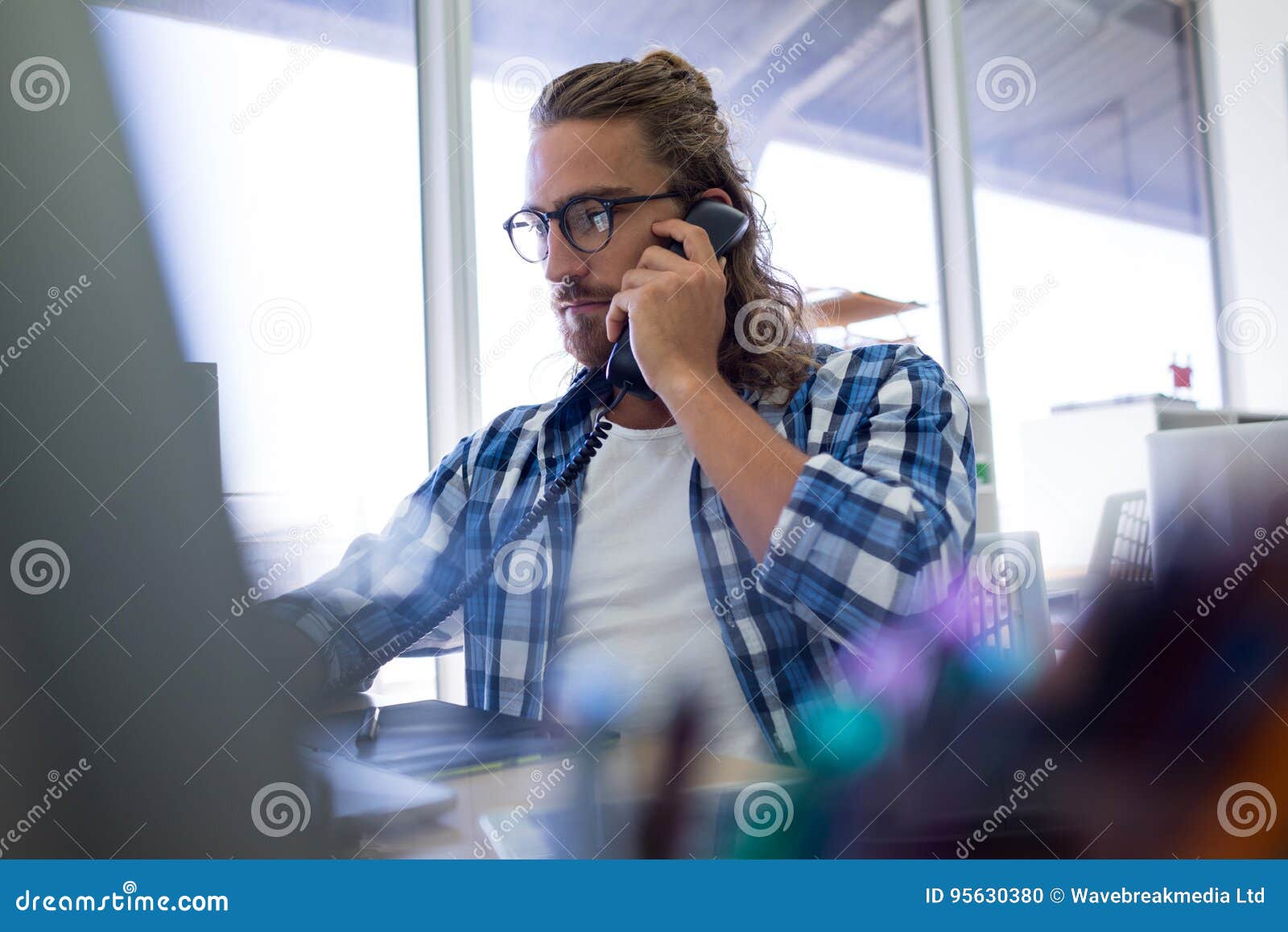 Male Executive Talking on Phone while Working at His Desk Stock Photo ...