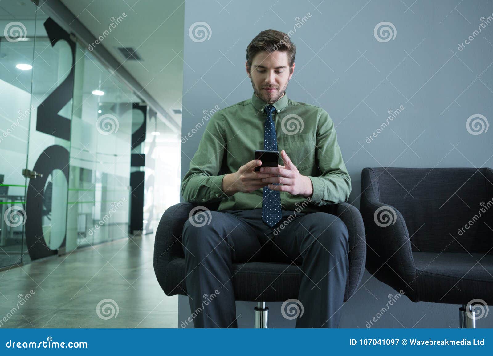 Male Executive Using Mobile Phone in Waiting Area Stock Image - Image ...
