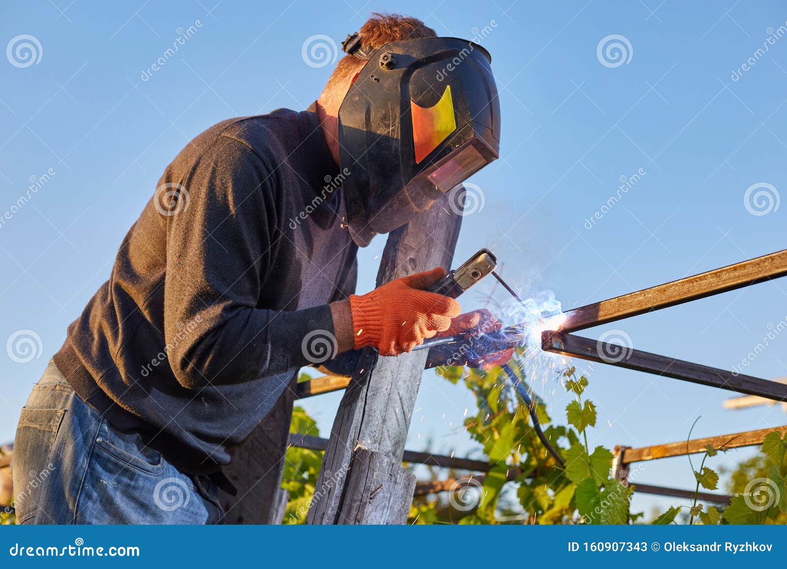 Male in face mask welds stock image. Image of overalls - 160907343