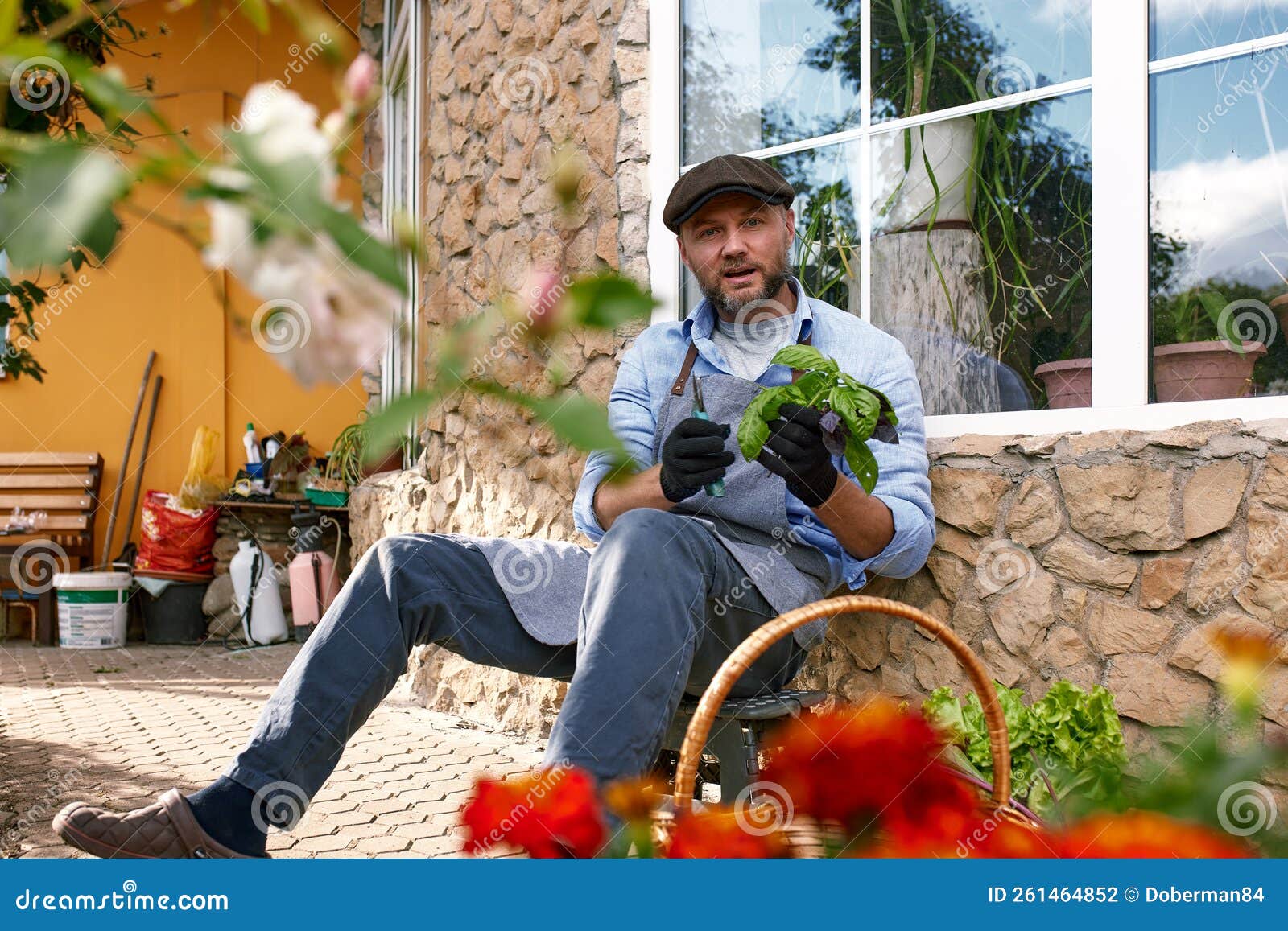 A Male Farmer Sitting in the Yard Outdoors, Resting. Stock Photo ...