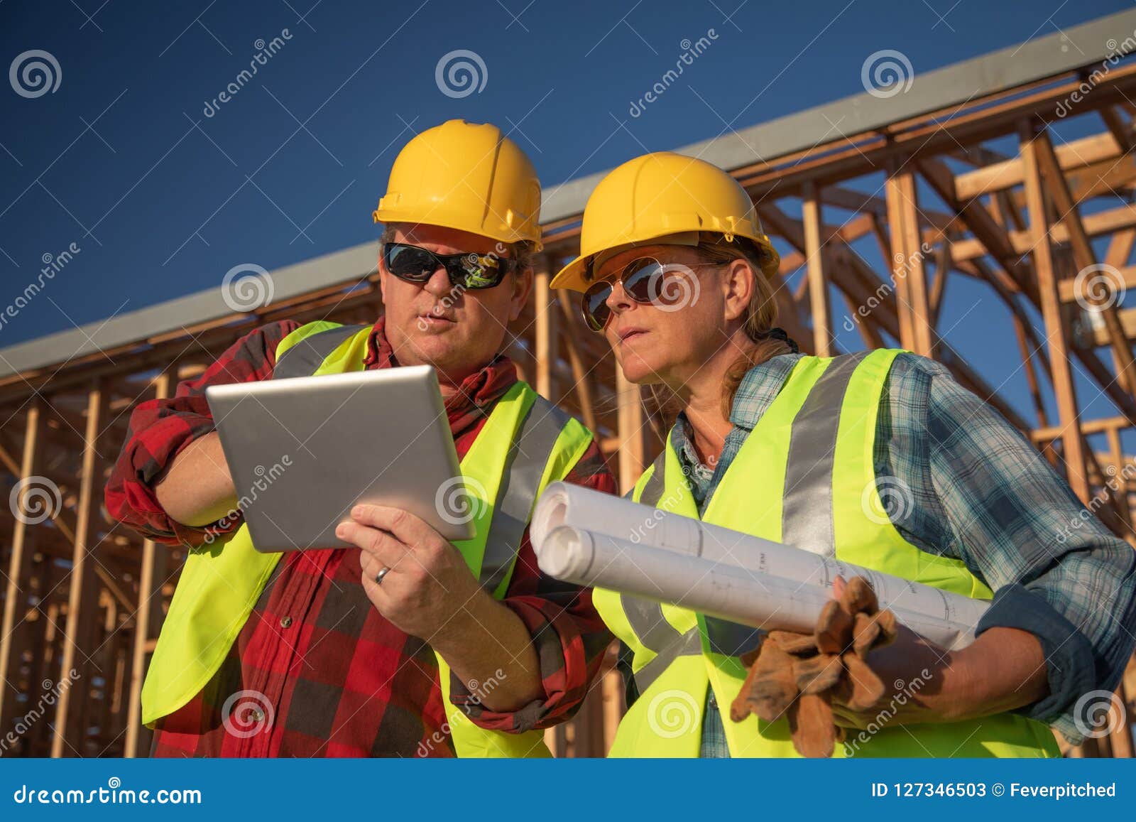 Male and Female Construction Workers Using Computer Pad Stock Image ...