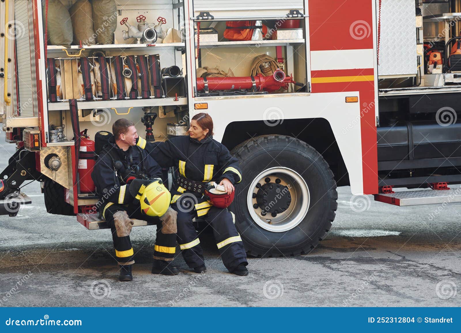 Male and Female Firefighters in Protective Uniform is Outdoors Together ...