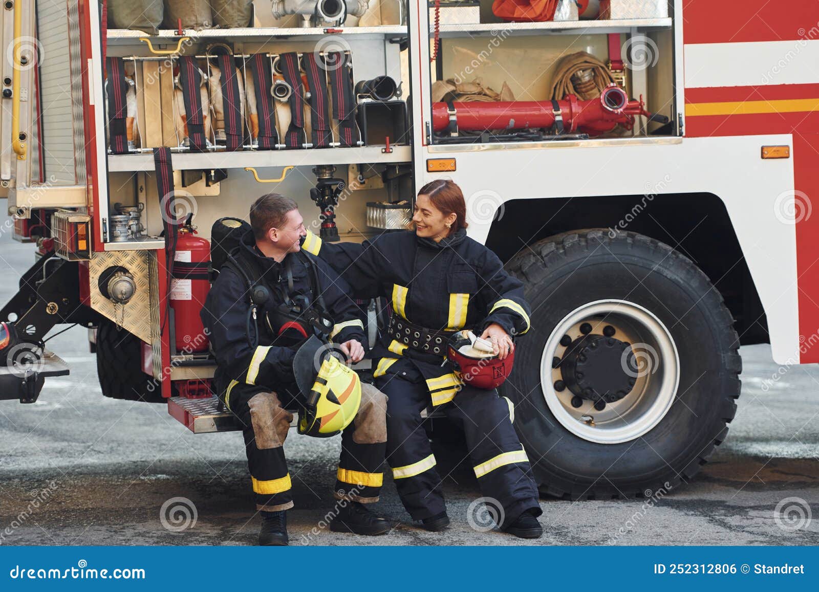 Male and Female Firefighters in Protective Uniform is Outdoors Together ...