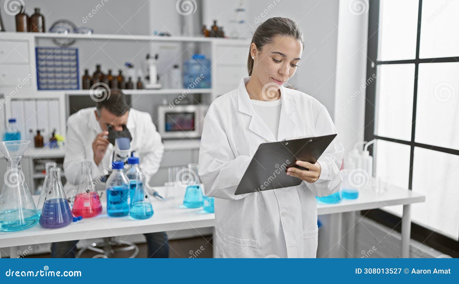 Male and Female Scientists Working Together in Lab, Serious ...