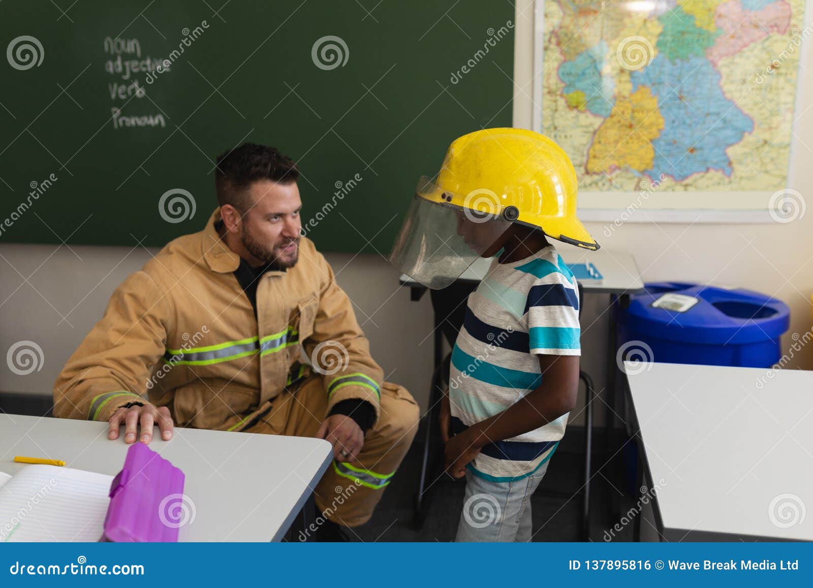 Male Firefighter Teaching Schoolboy about Fire Safety in Classroom ...