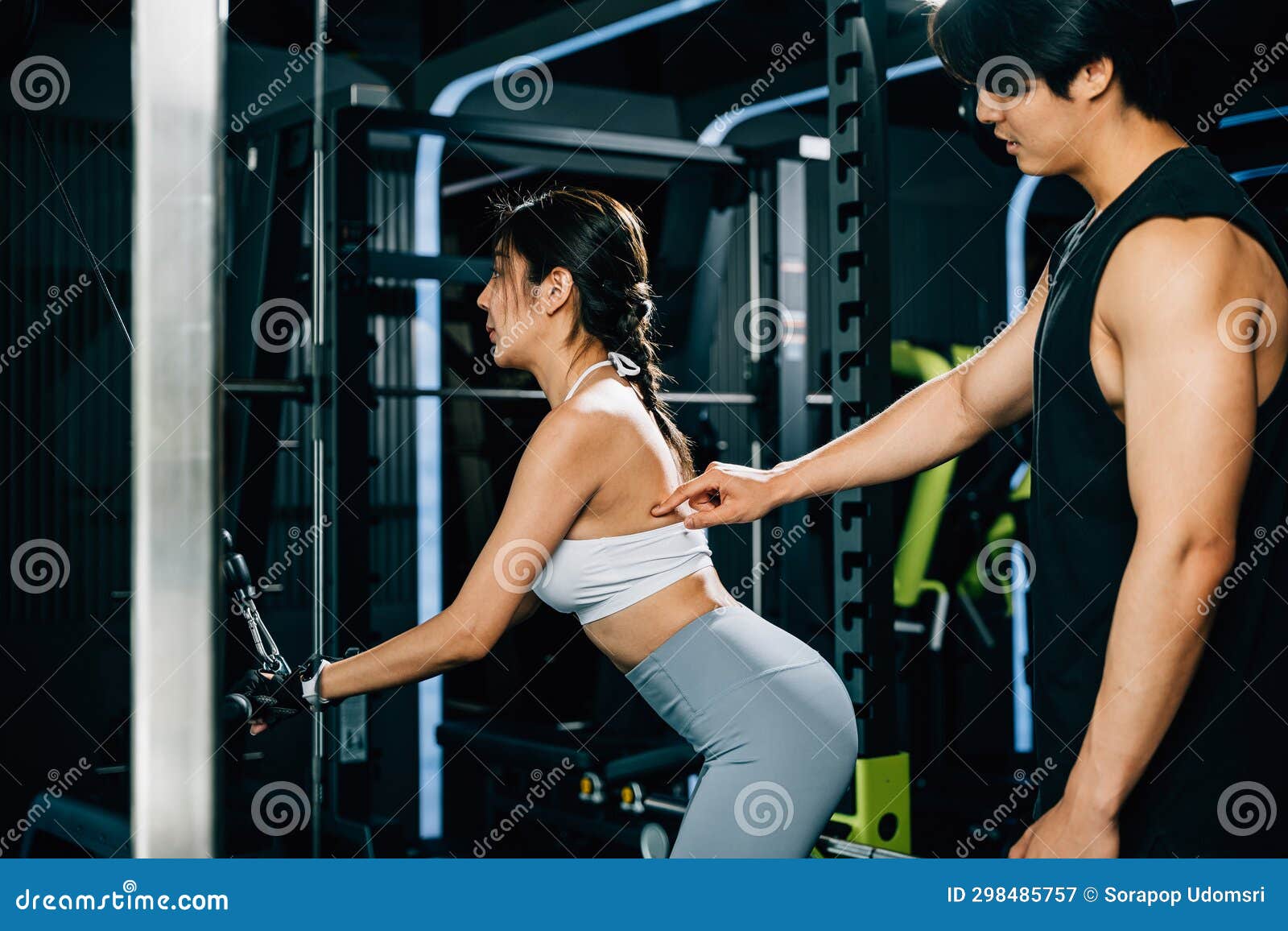 Male Fitness Coach Teaching a Woman How To Use a Pulldown Cable Machine ...