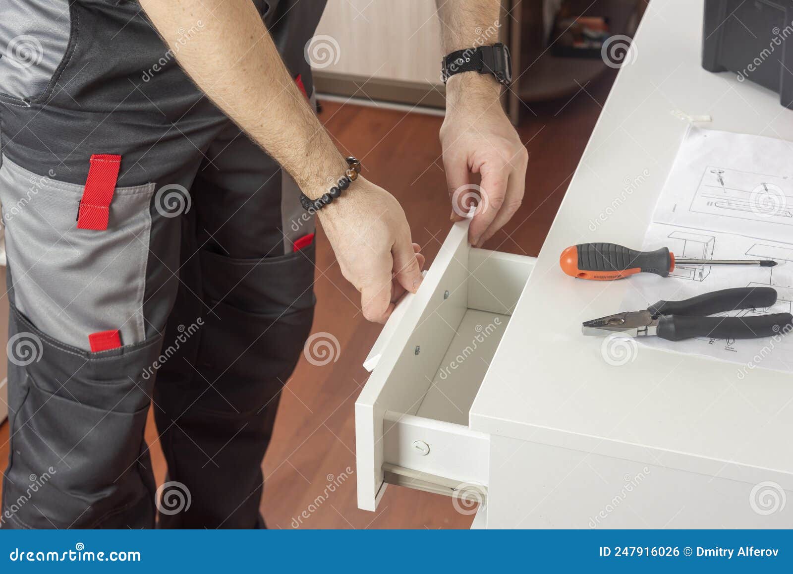 A Male Furniture Assembler is Engaged in Assembling a Desk with a ...