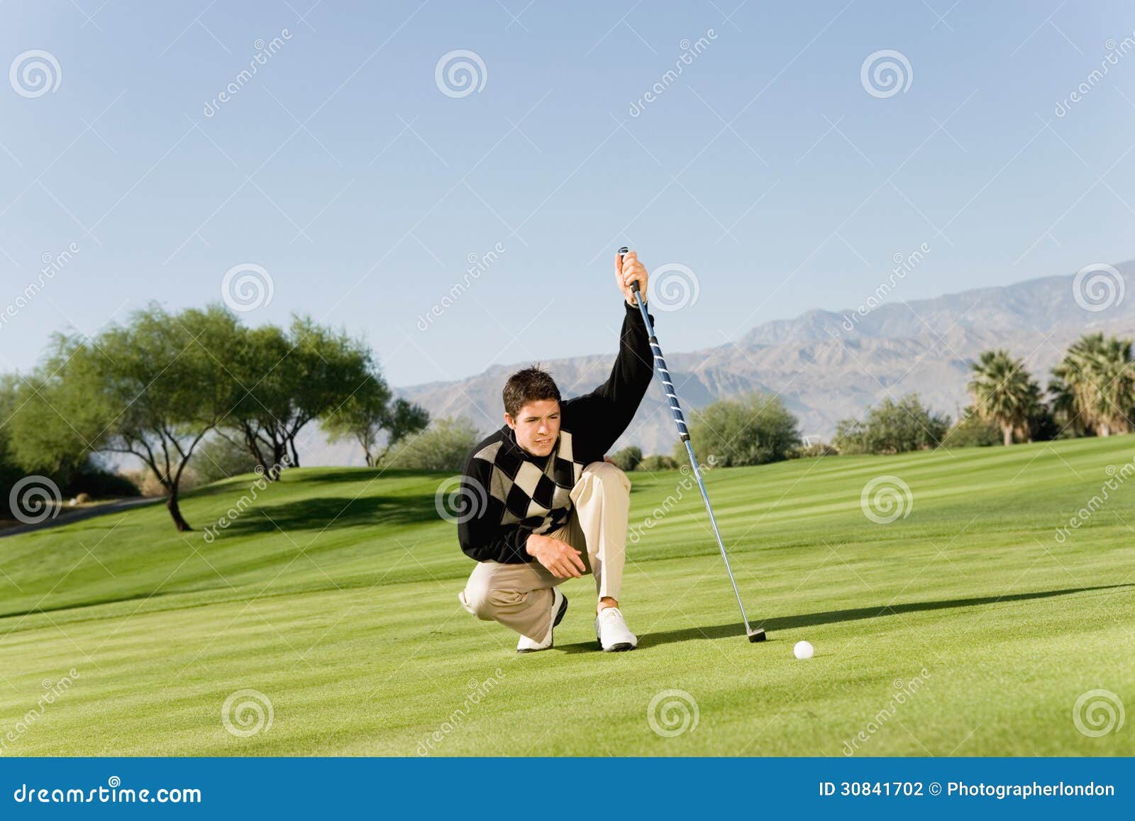 Male Golfer Lining Up Putt stock photo. Image of concentration - 30841702