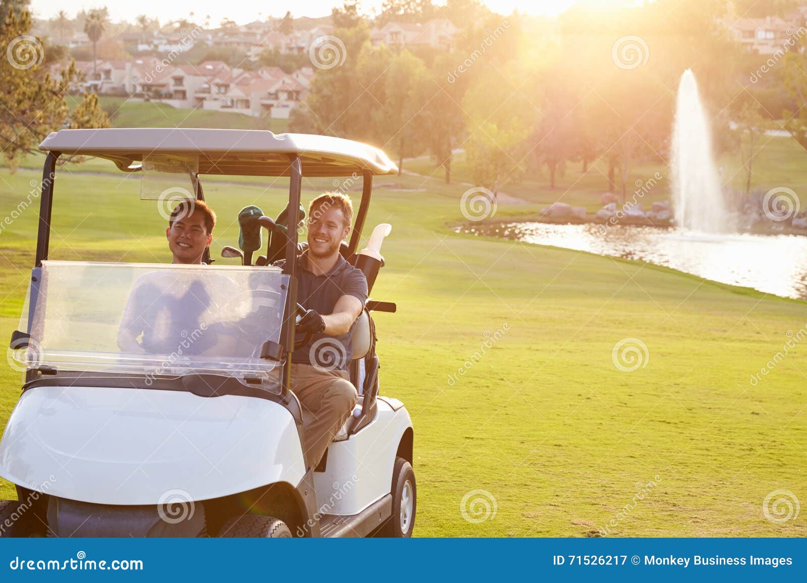 Male Golfers Driving Buggy Along Fairway of Golf Course Stock Image ...