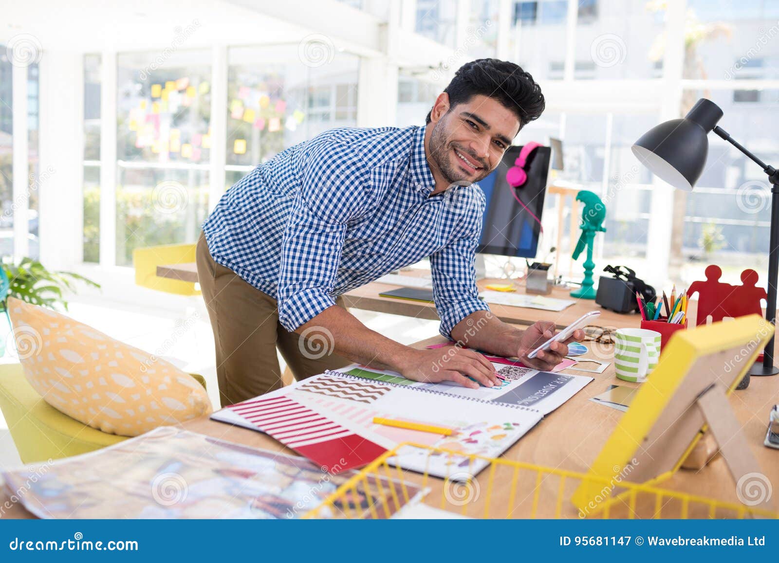 Male Graphic Designer Using Mobile Phone while Working at Desk Stock ...