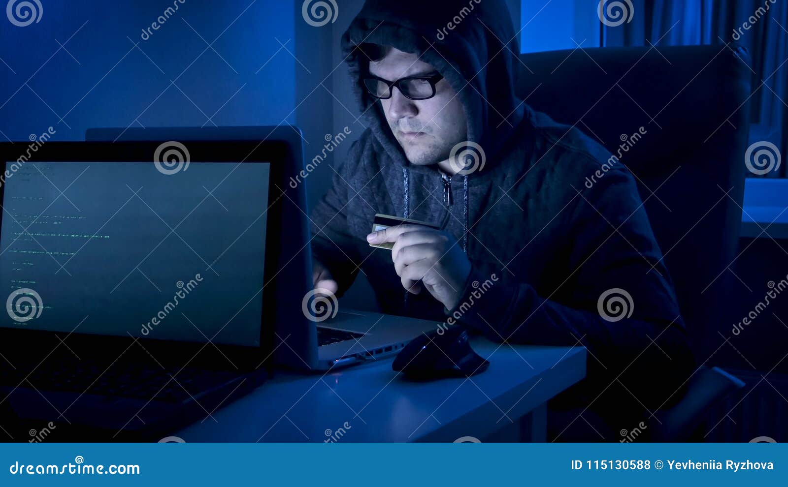 Portrait of Male Hacker Holding Credit Card and Typing Fraud Program ...