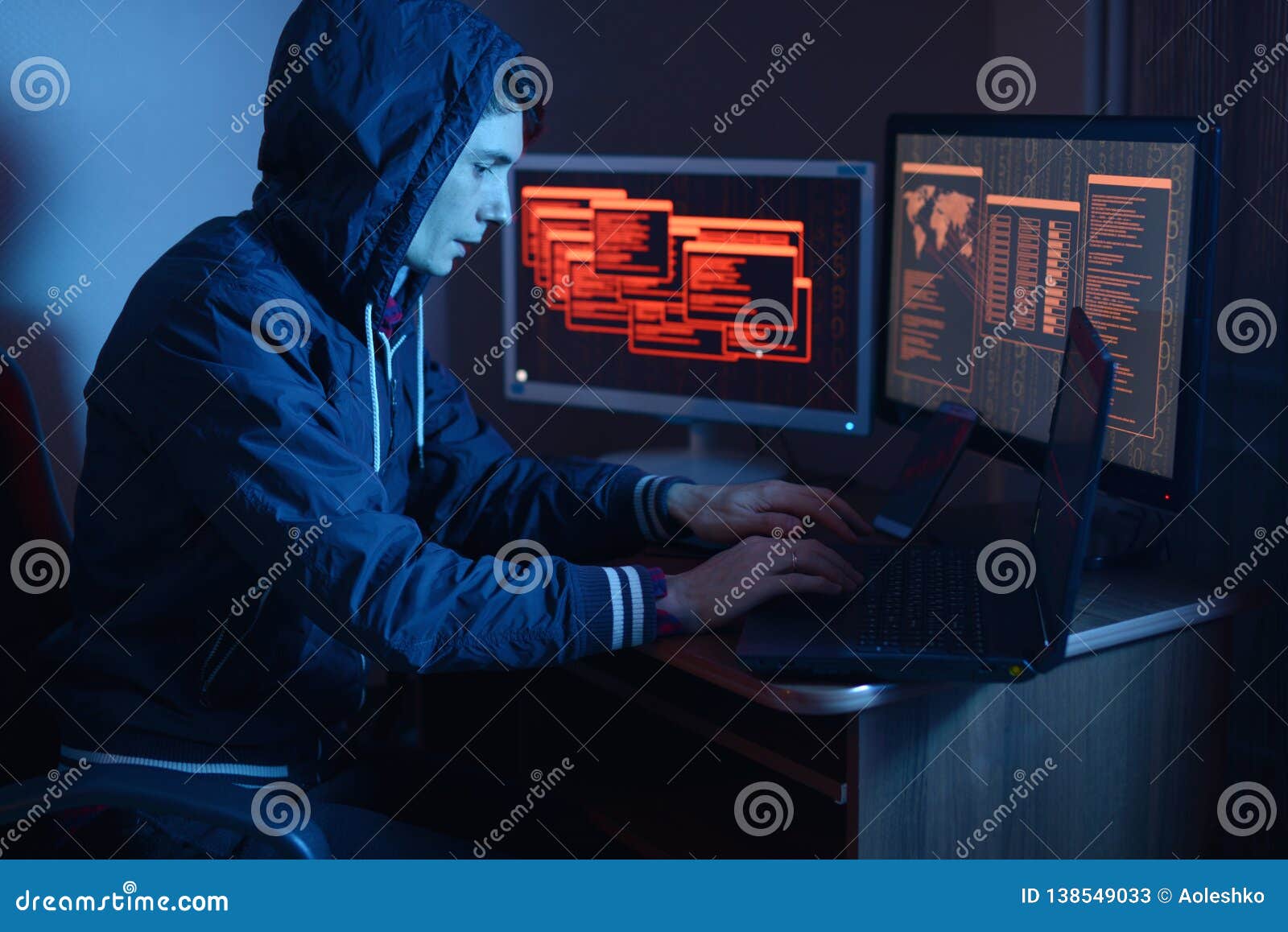 Hacker In A Hood Typing Program Code While Committing A Cybercrime On