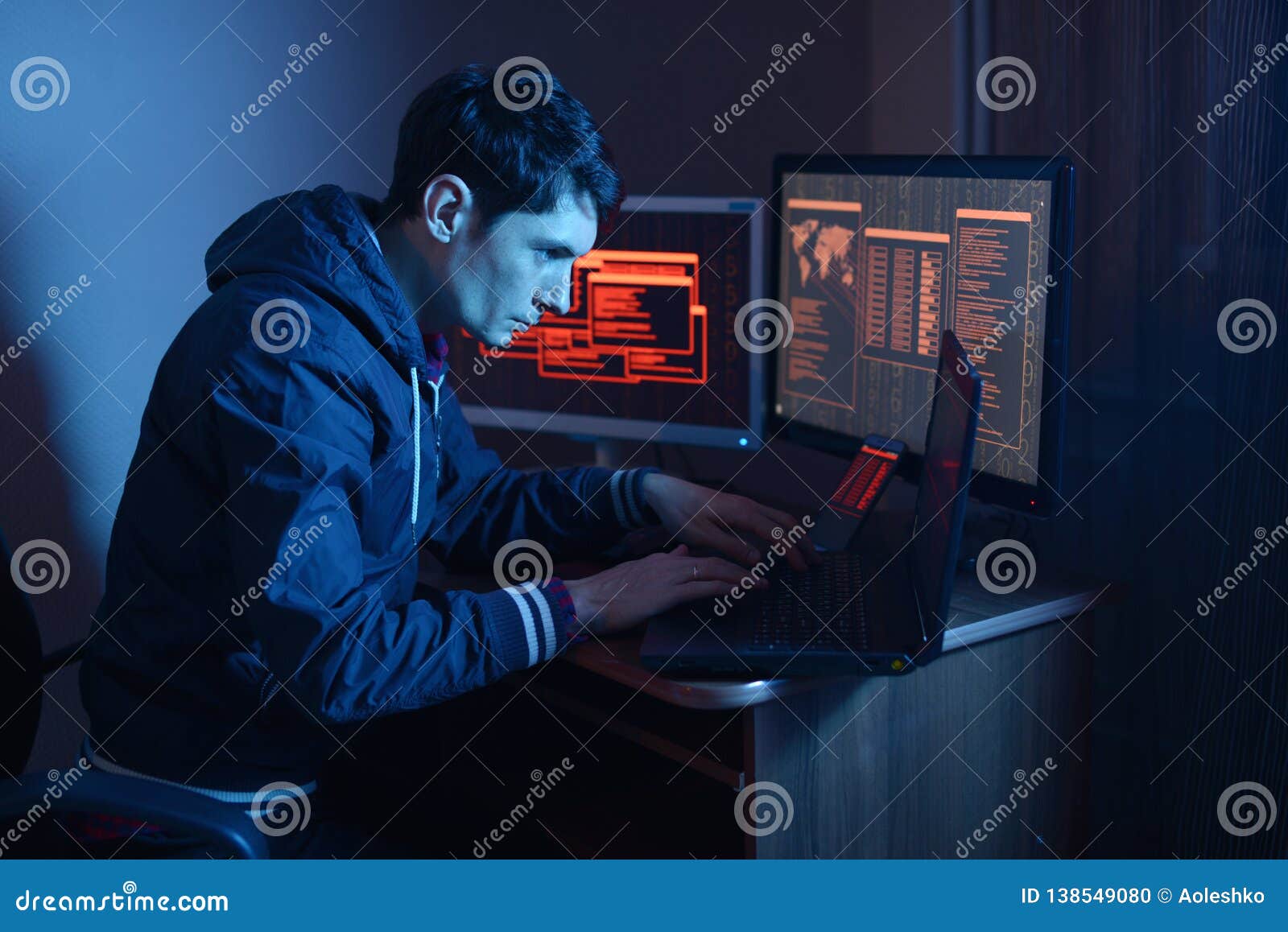 Hacker In A Hood Typing Program Code While Committing A Cybercrime On