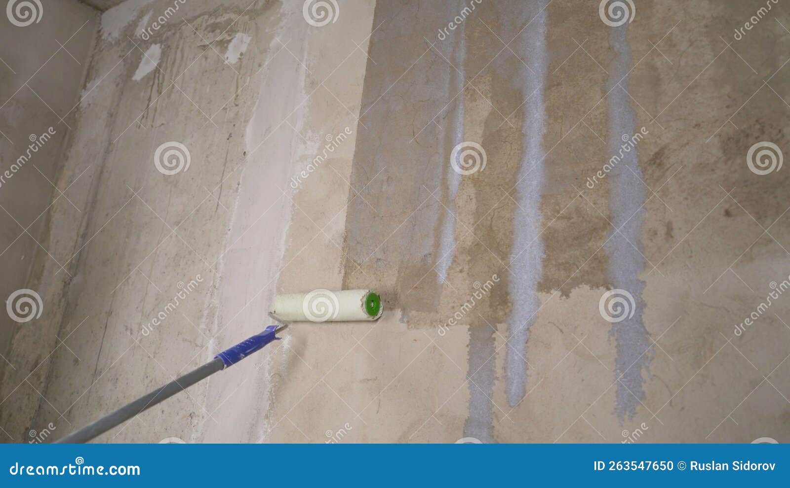 Male Hand Applies Fresh Paint and Primer To the Surface of the Wall ...