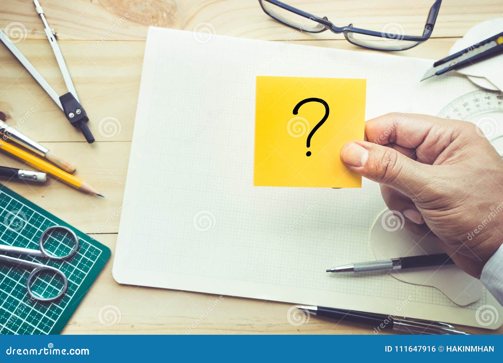 Male Hand Holding Notepad with Question Marks on Work Table Stock Photo ...