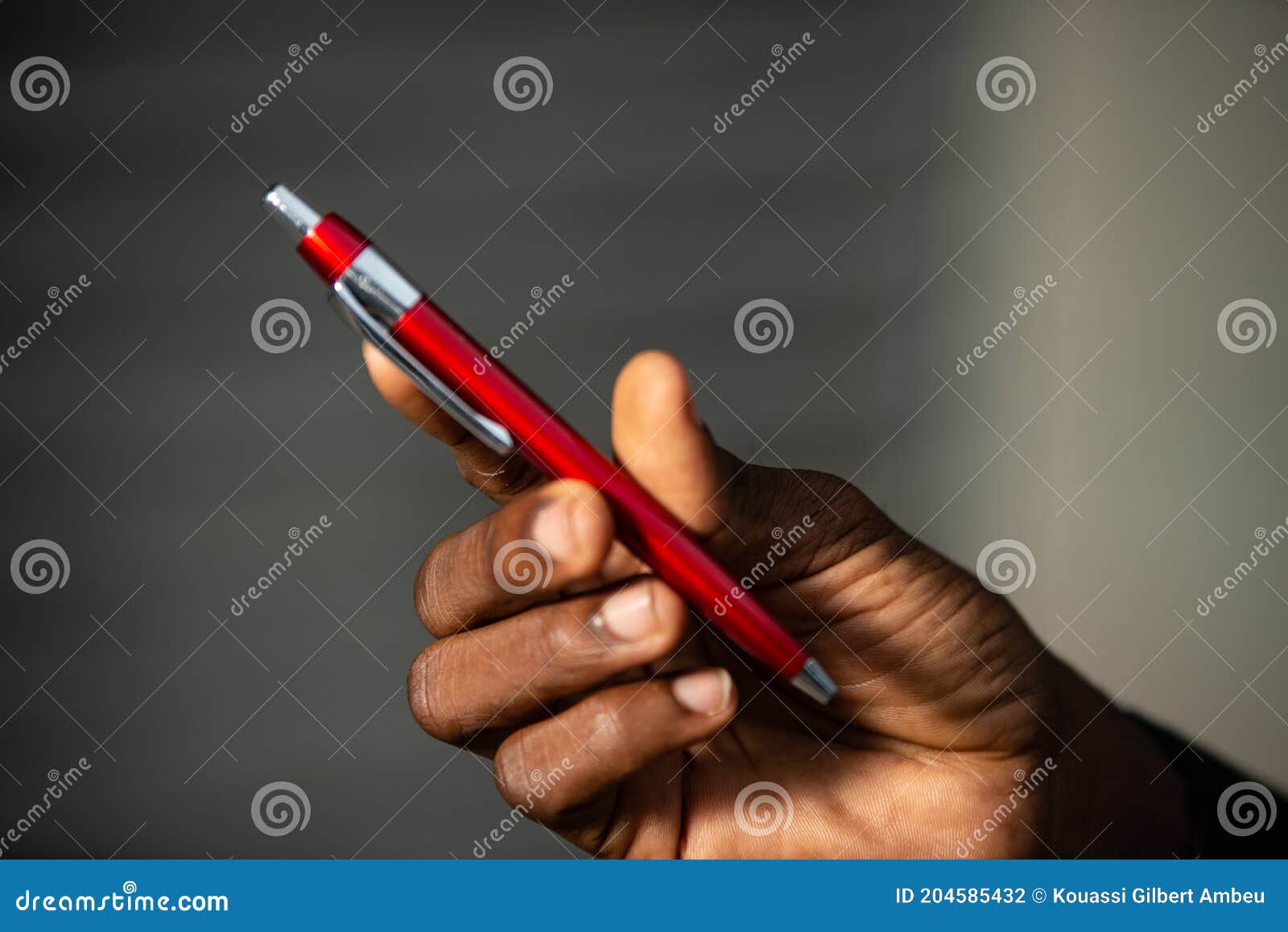 Male hand holding a pen stock photo. Image of business - 204585432