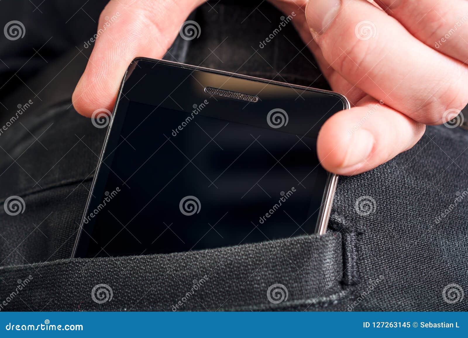 Male Hand Pulling a Black Smartphone with Copy Space Out of a Dark ...