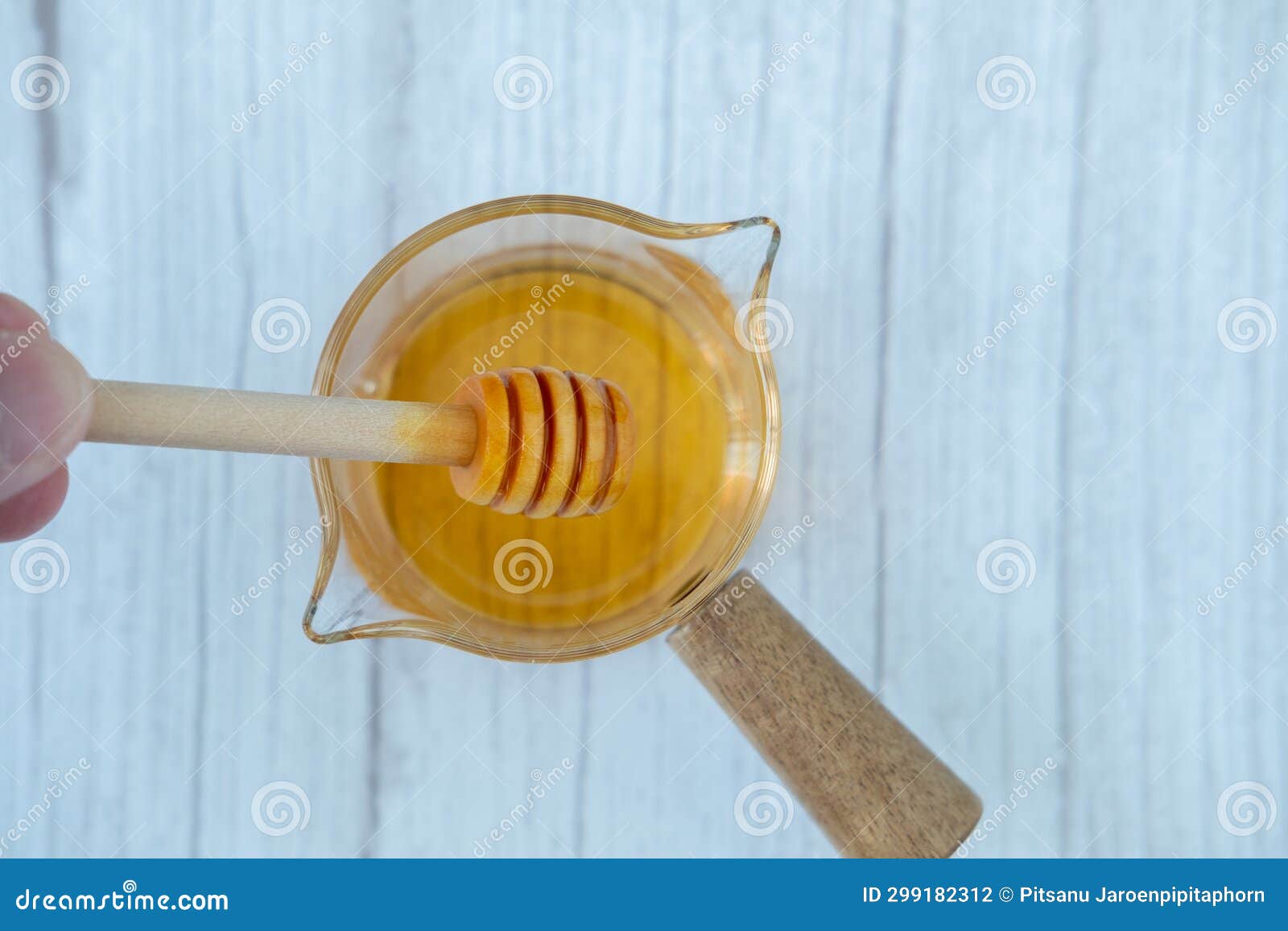 Male Hand Using a Stick for Stirring Honey in a Measuring Cup Stock ...